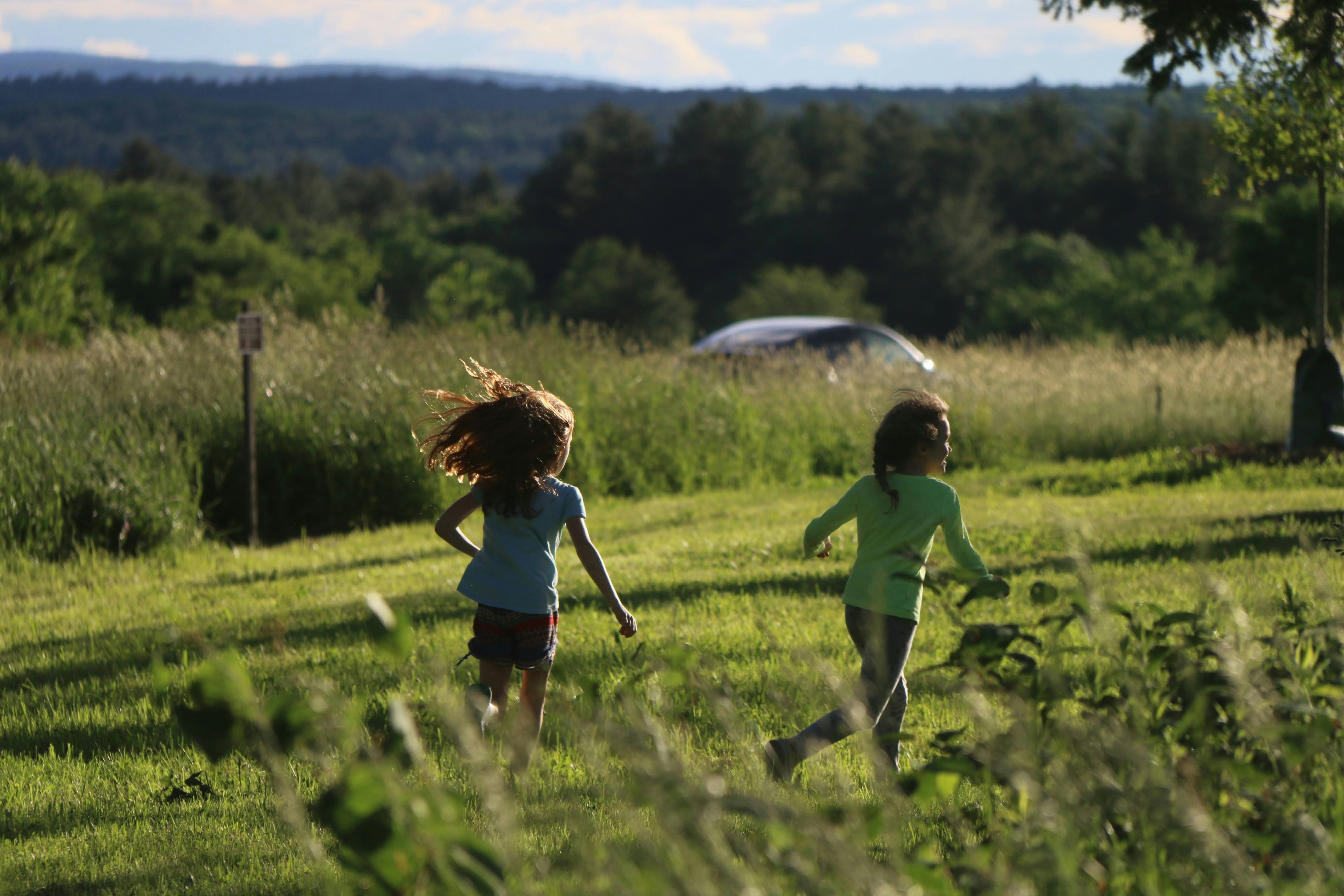 Two children running in a grassy field photo – Free Human Image on Unsplash
