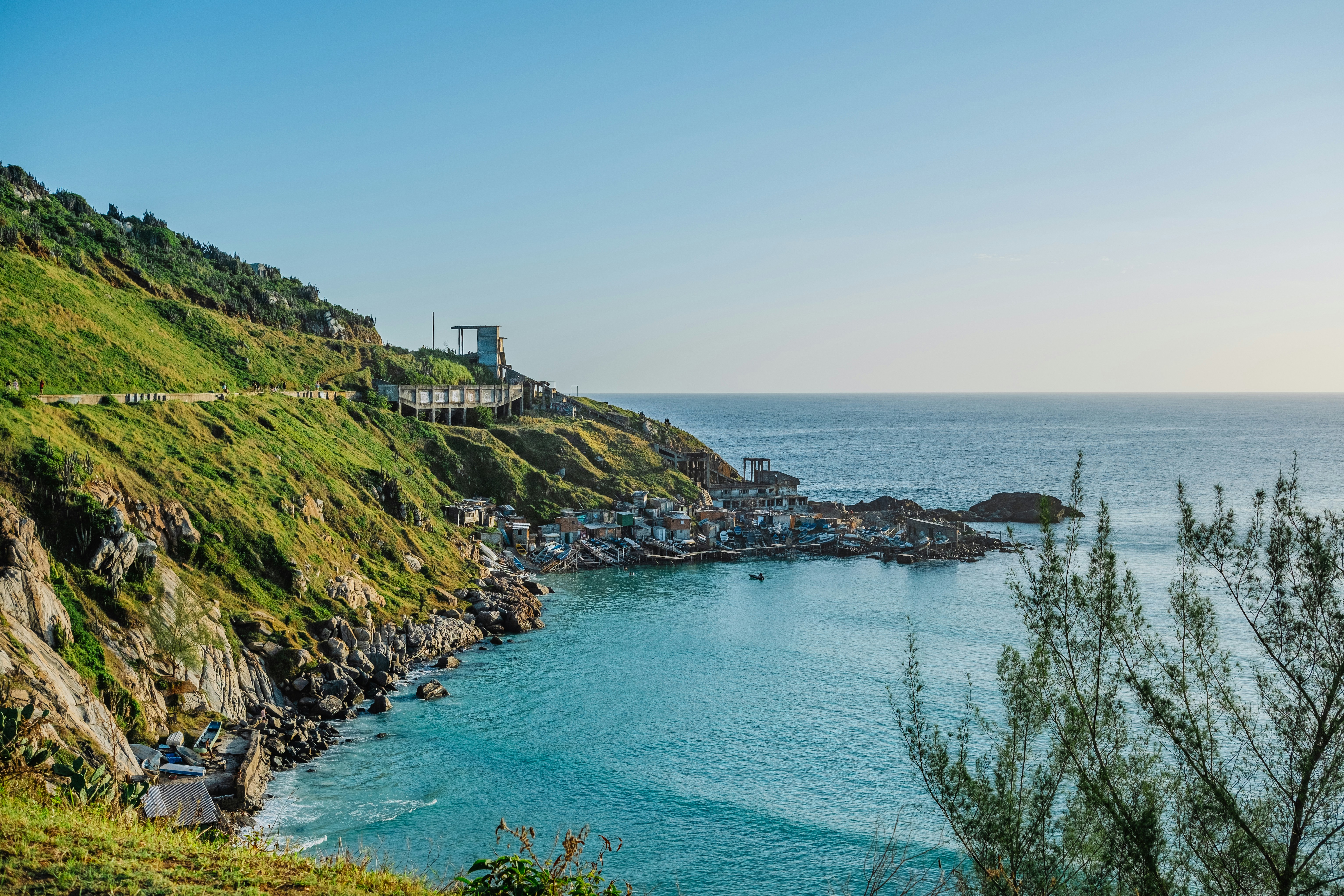 Vibrant coastline with lush greenery and clear blue waters under a bright sky.