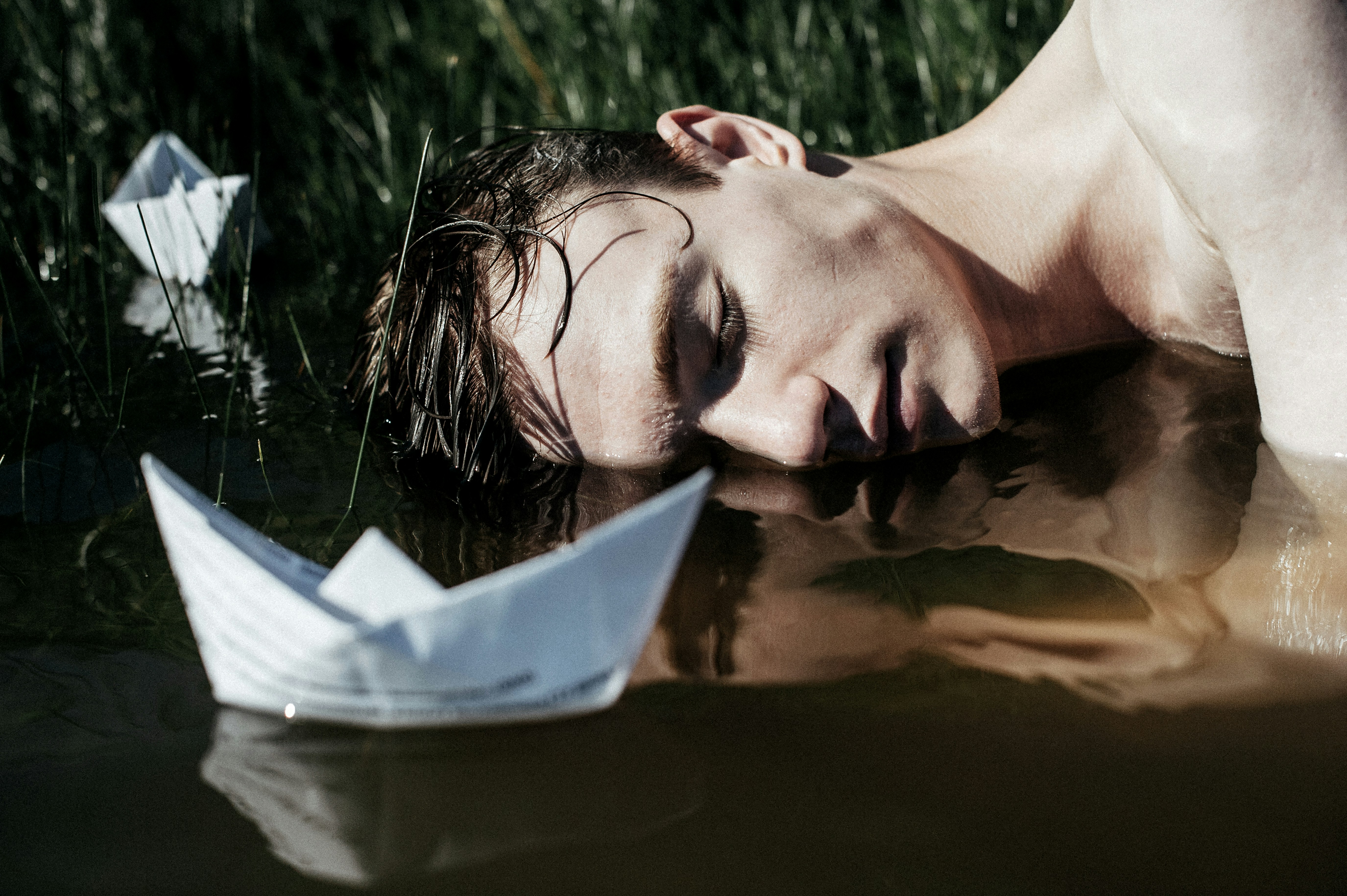Quiet Drift: A Portrait Cast in Water Among Paper Boats