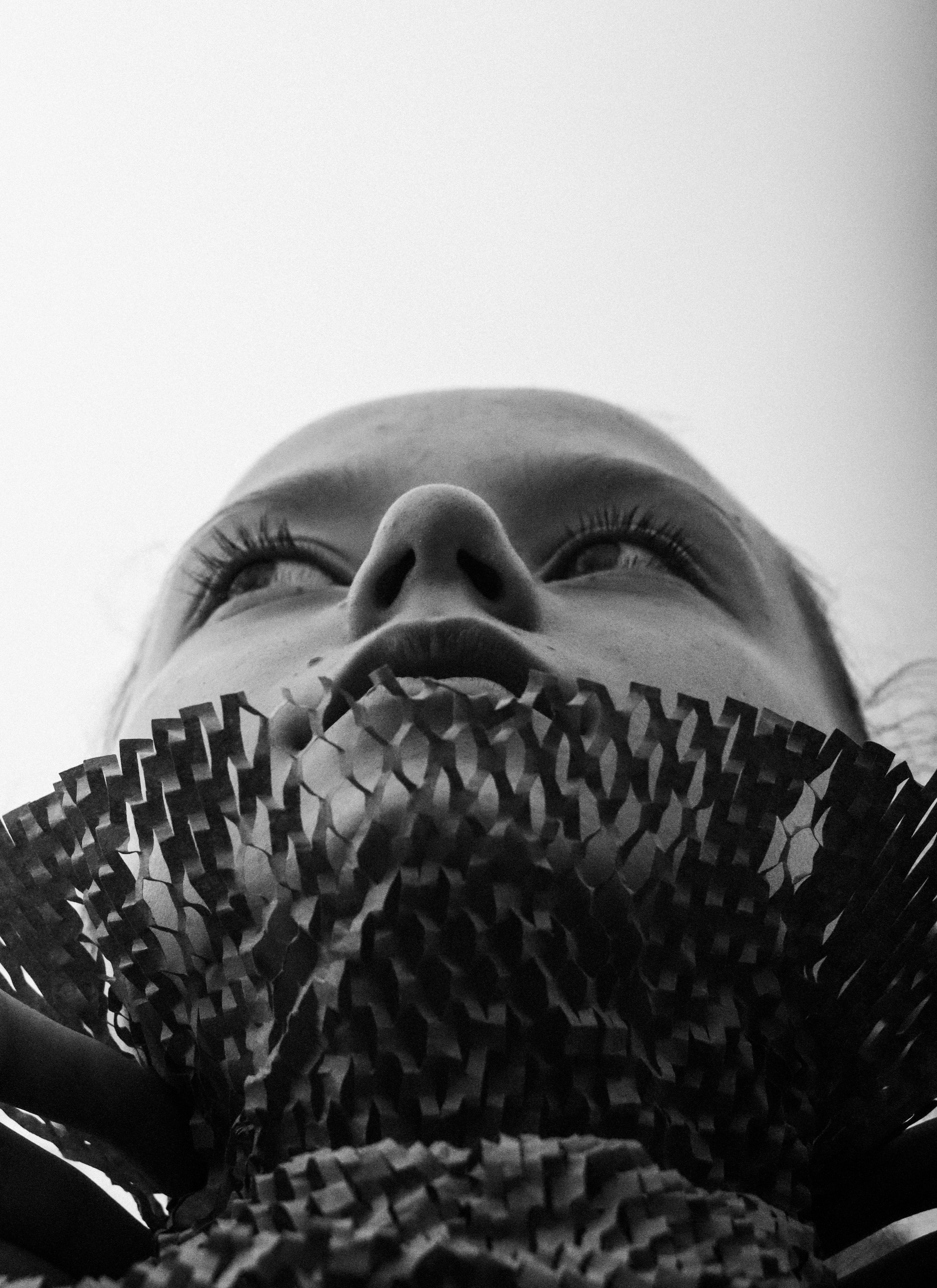 Upward Gaze Beneath a Sculpted Pleated Collar