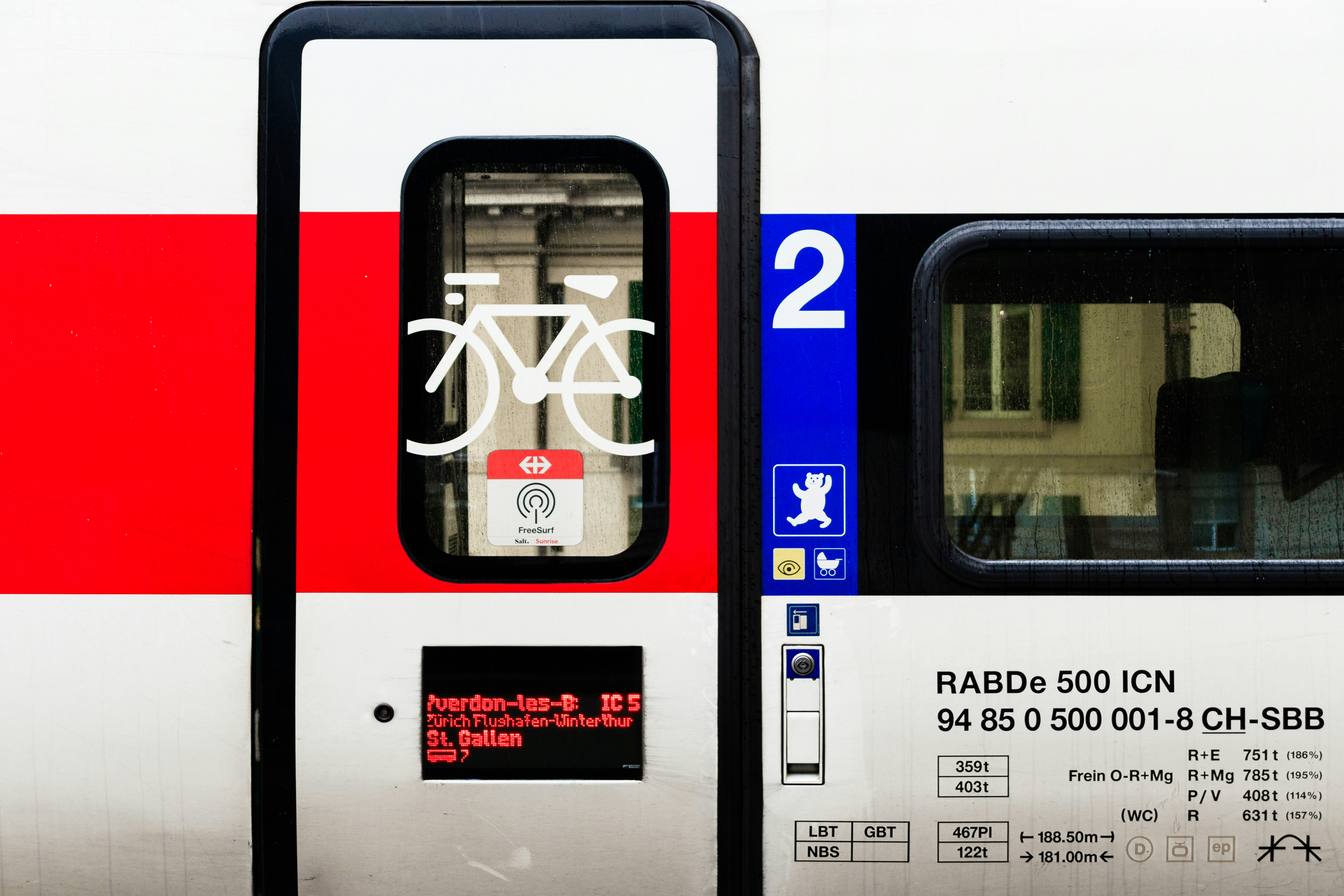 Train door featuring a bicycle symbol and route information, emphasizing accessibility for cyclists. The design showcases modern transit integration.