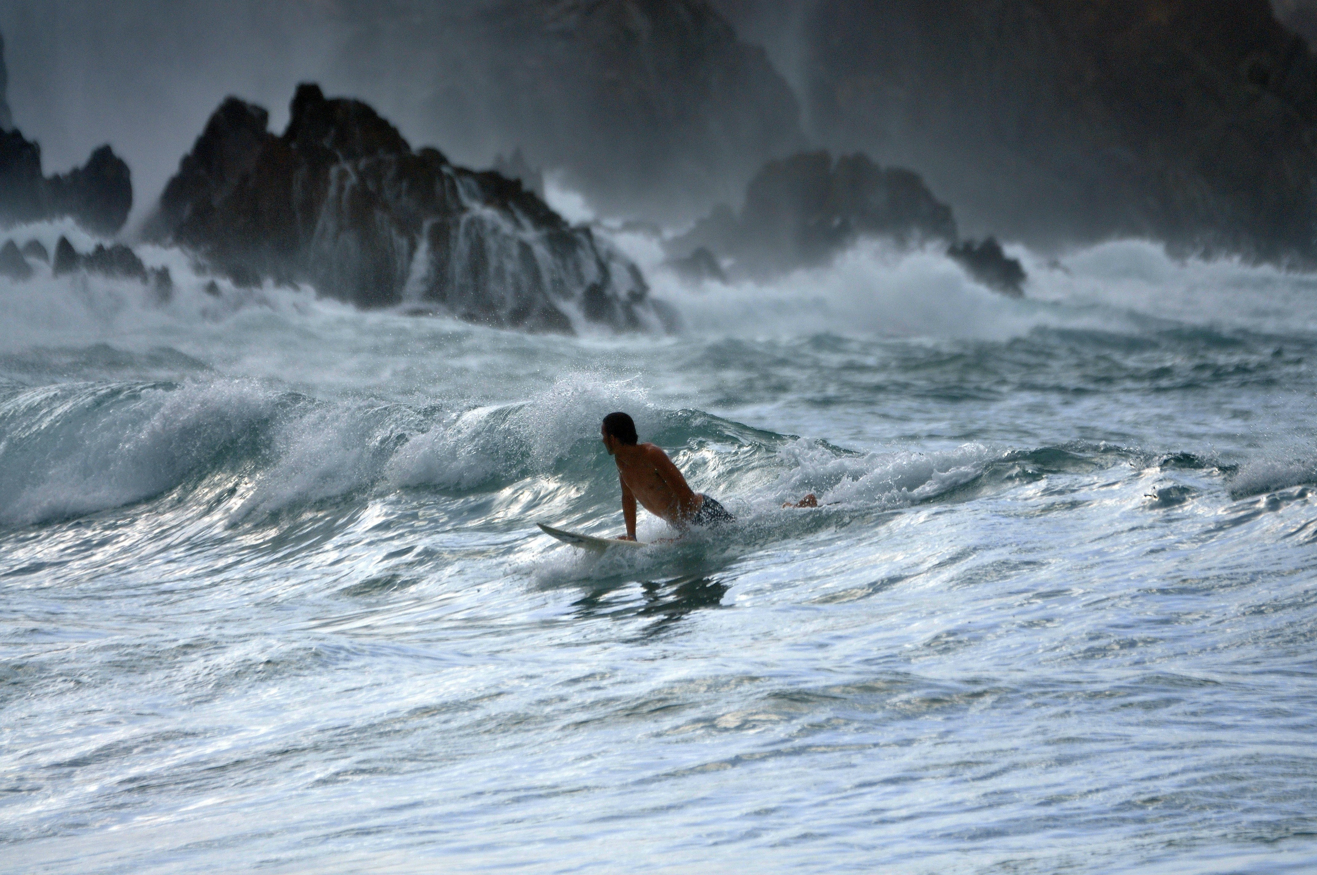Lone Surfer Braving Mist and Granite Waves