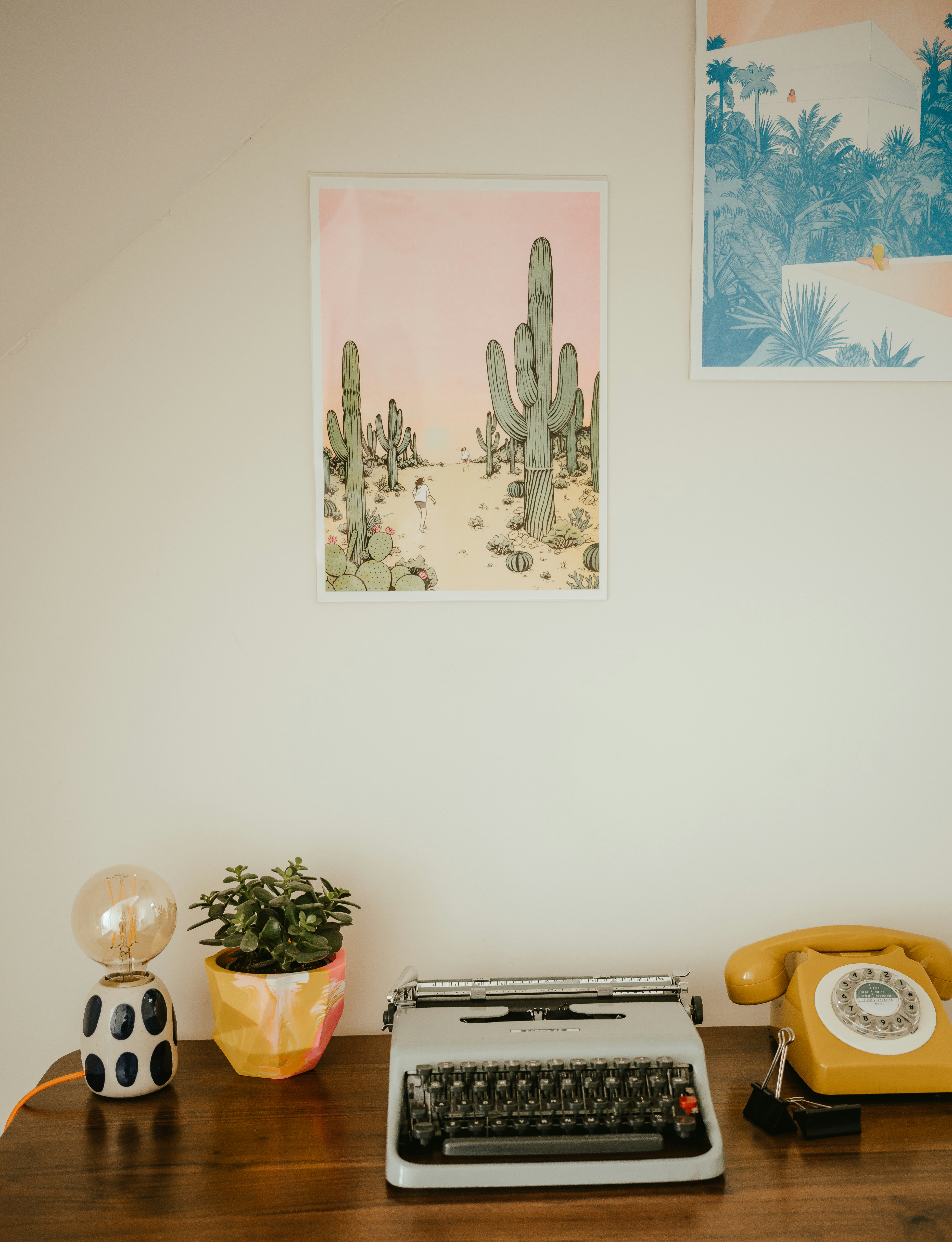 Vintage typewriter on a wooden desk surrounded by decorative plants and colorful artwork. The scene evokes a creative and nostalgic atmosphere.