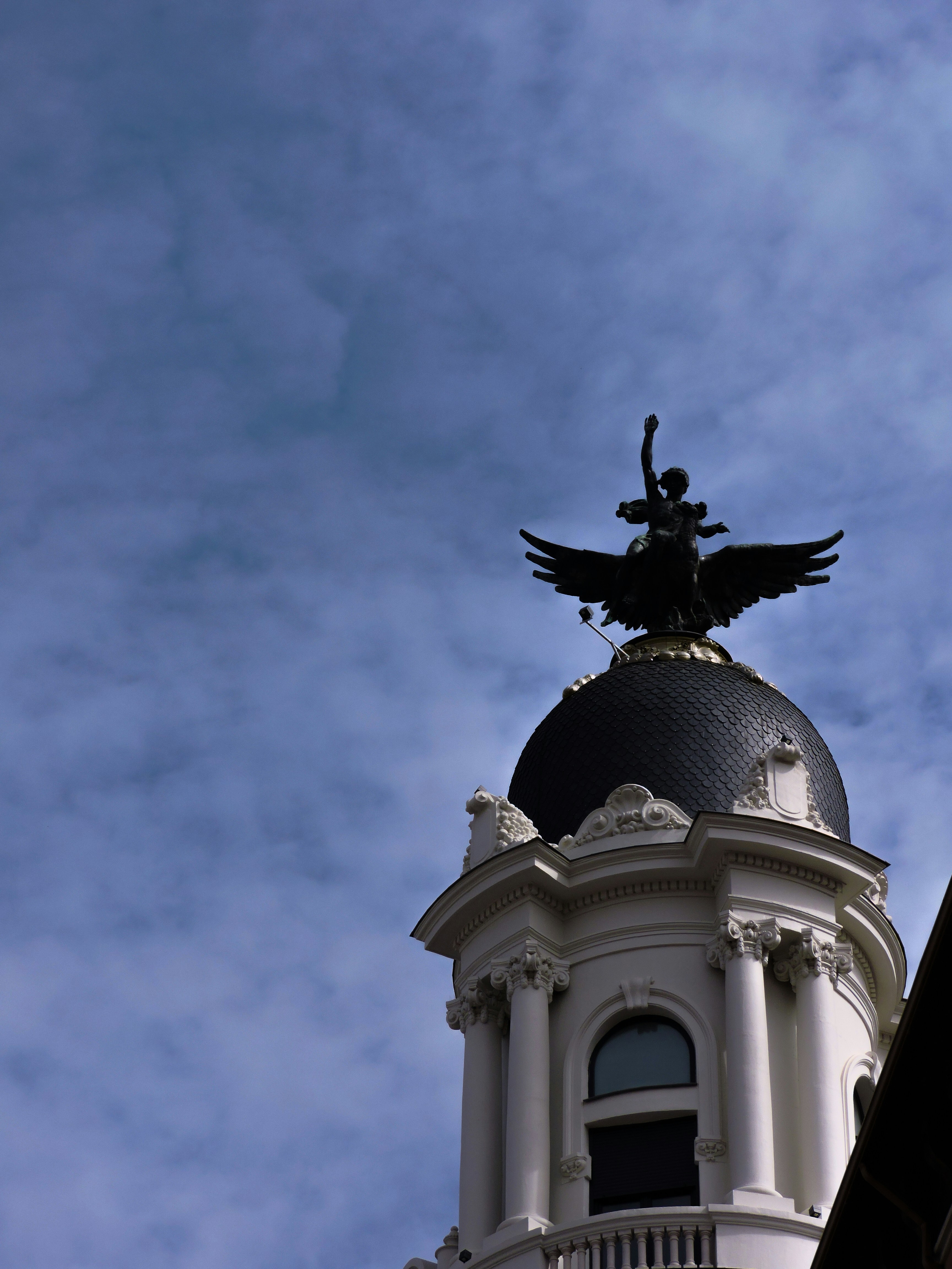 Winged Guardian on a Neo-Classical Dome Against a Clear Blue Sky