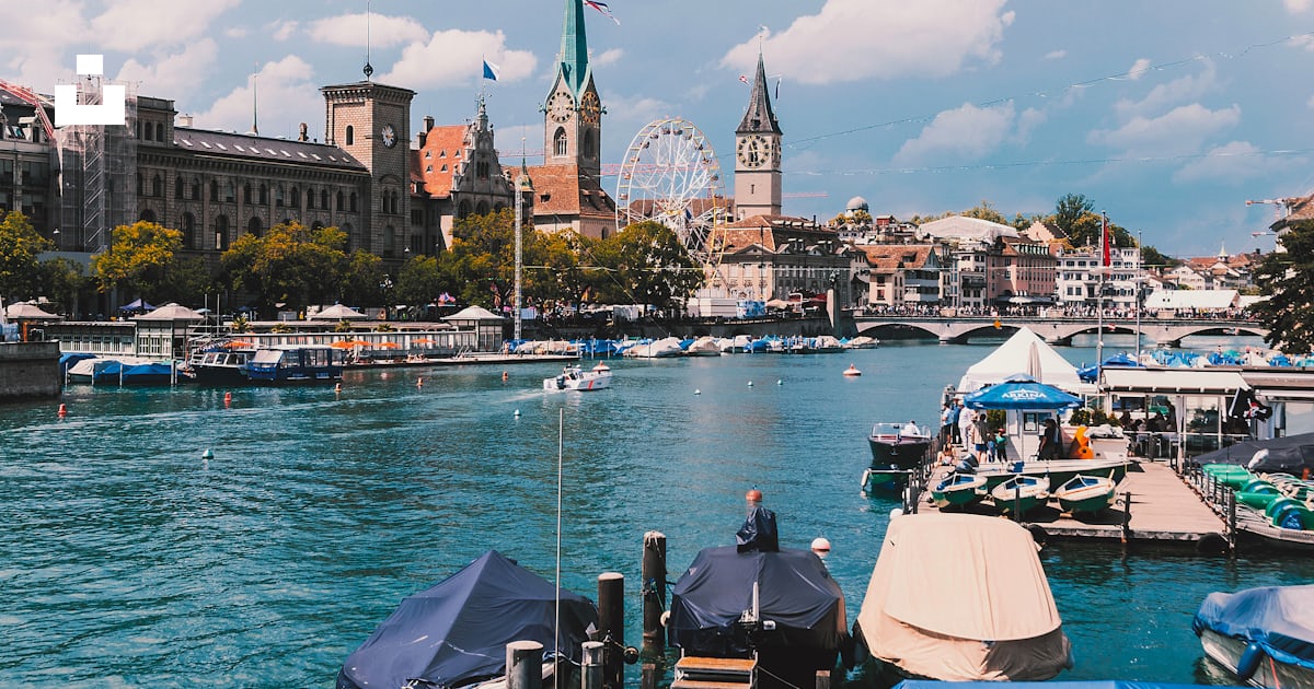 보트와 건물을 배경으로 한 수역 사진 Unsplash의 무료 스위스 이미지