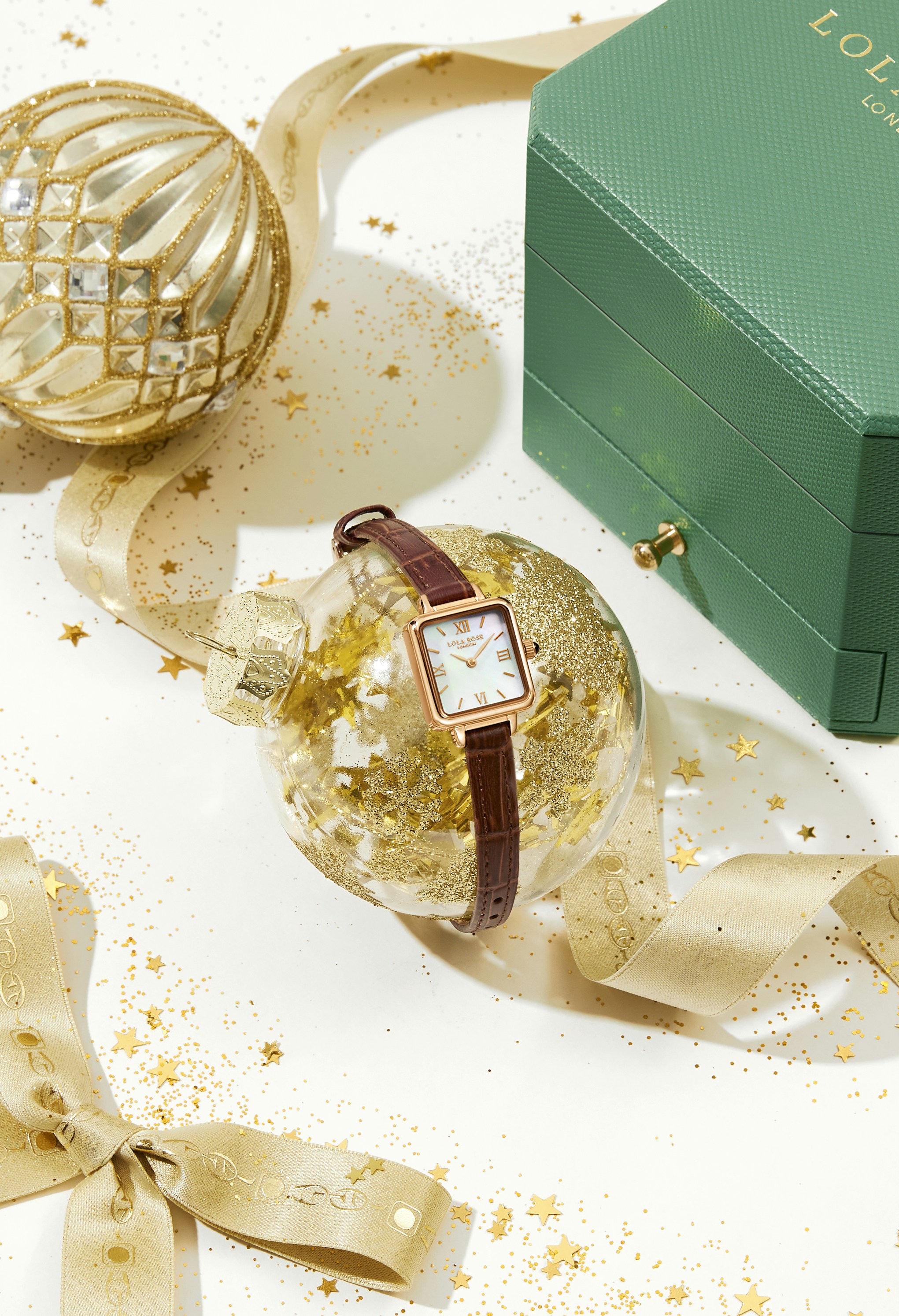 Holiday Timepiece: A Rose-Gold Watch Resting on a Glittering Ornament