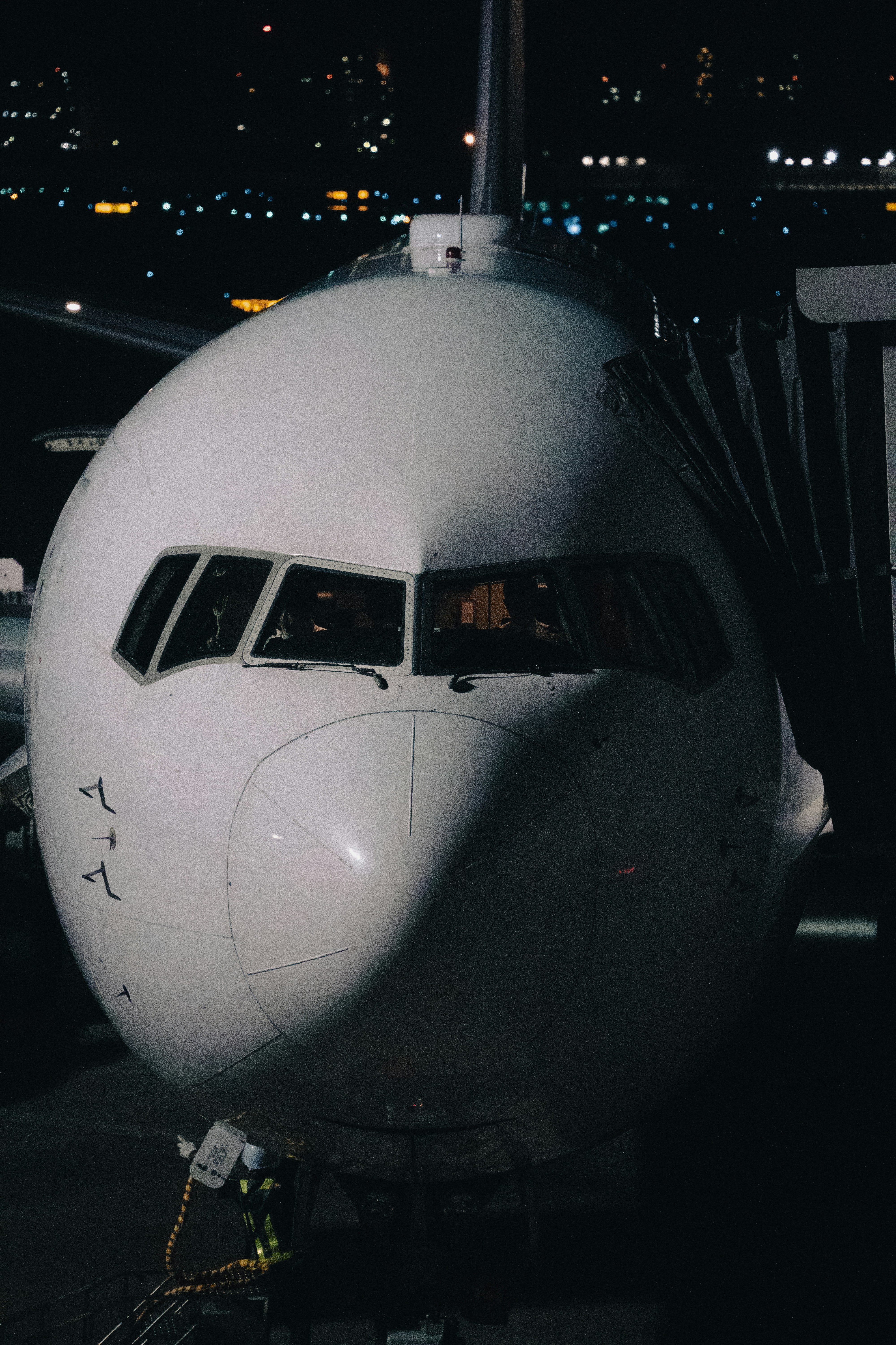 Close-up of an aircraft's nose and cockpit illuminated at night, showcasing the intricate details of the aircraft's design.
