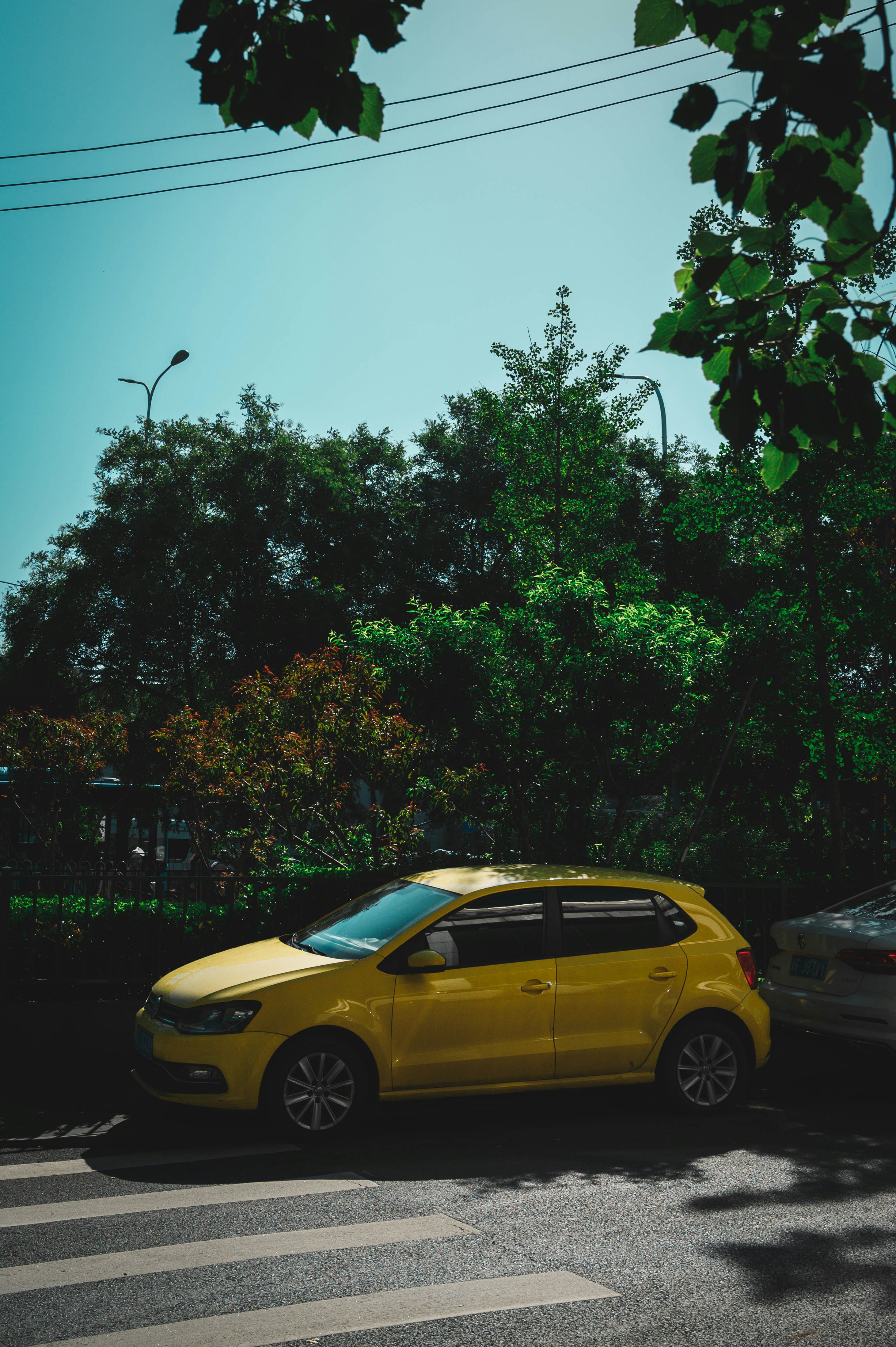 a yellow car parked on the side of a road