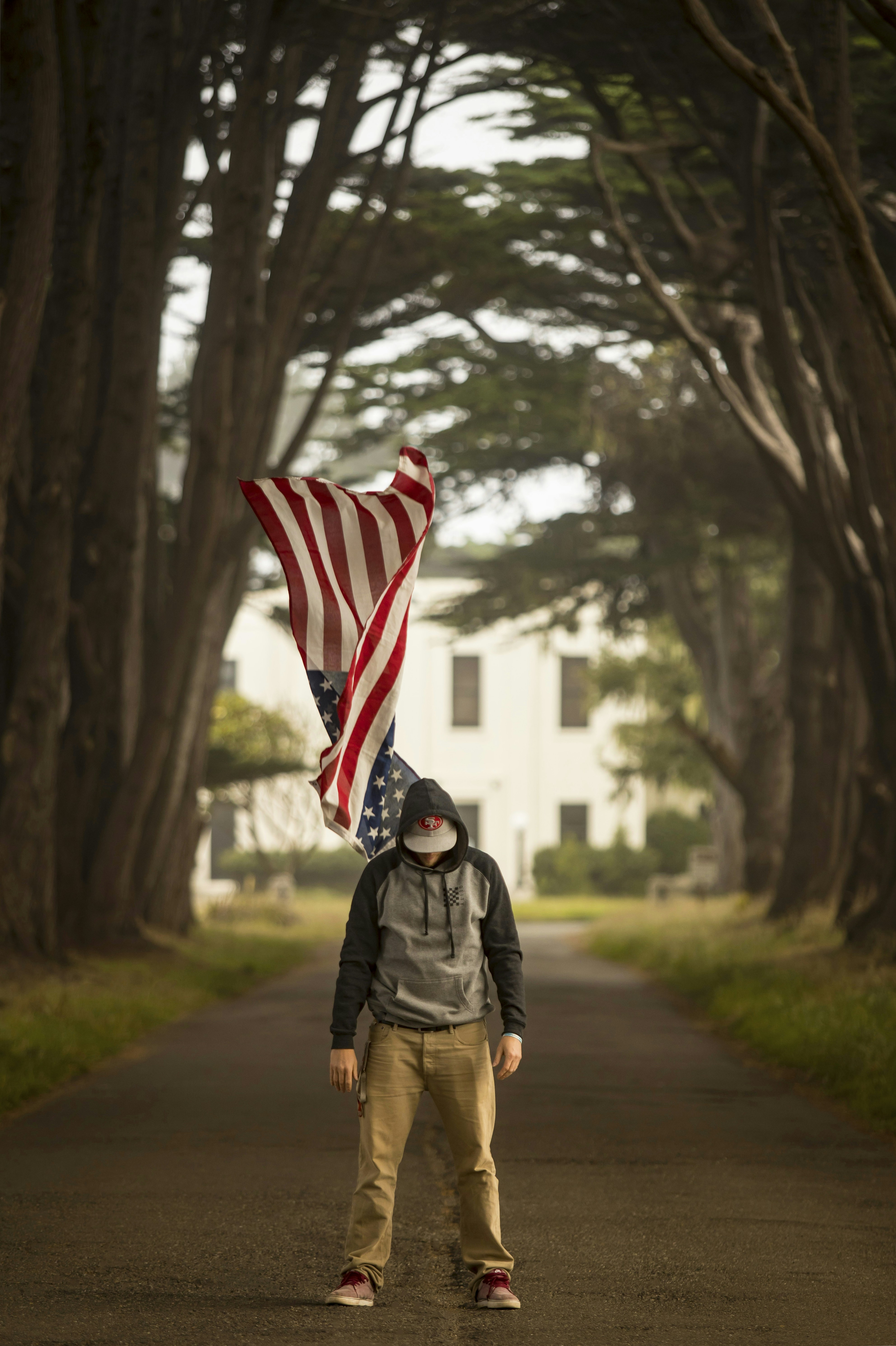 a person standing on a road with a flag on the head