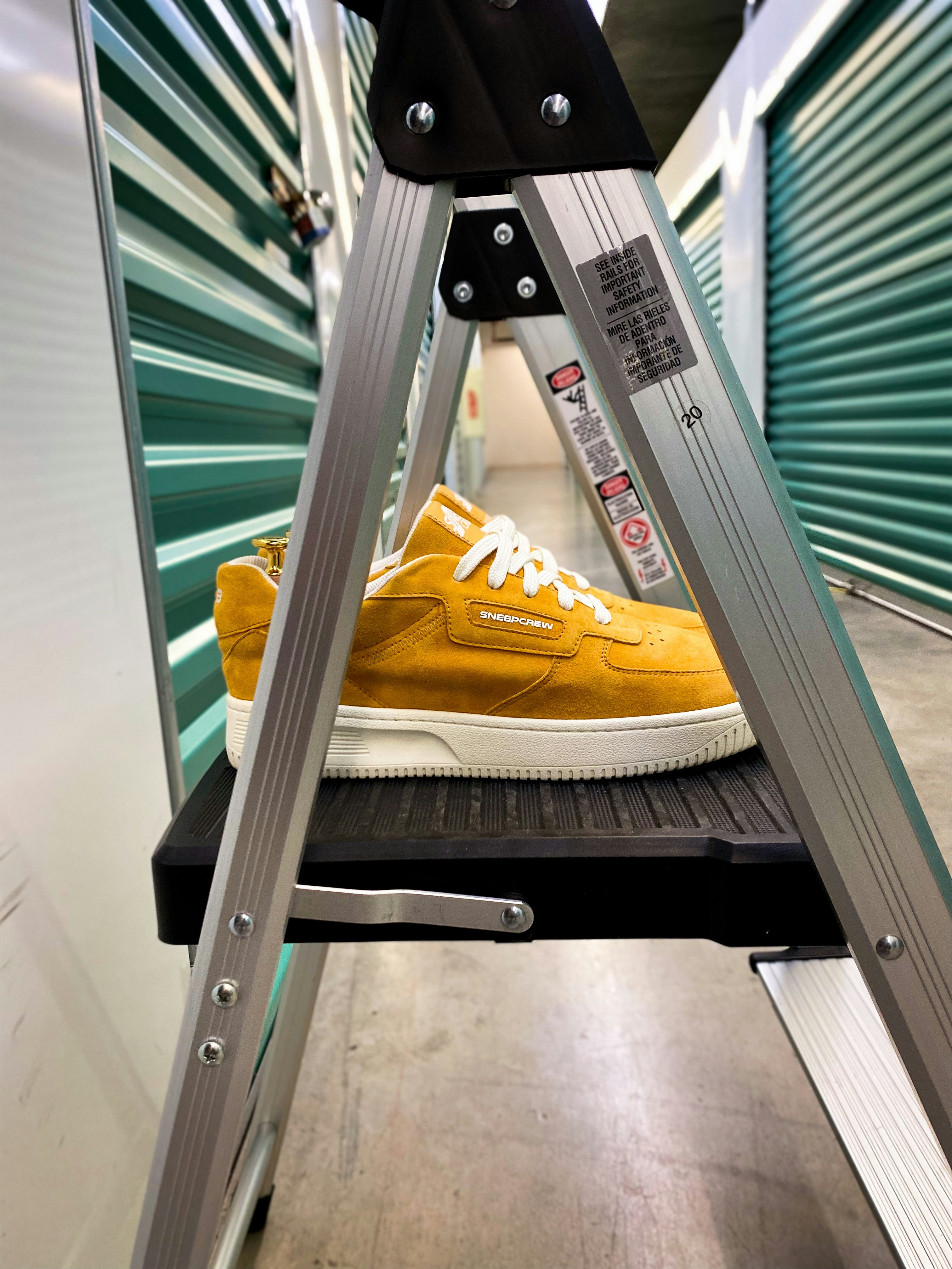 Yellow sneaker under a ladder in a storage hallway