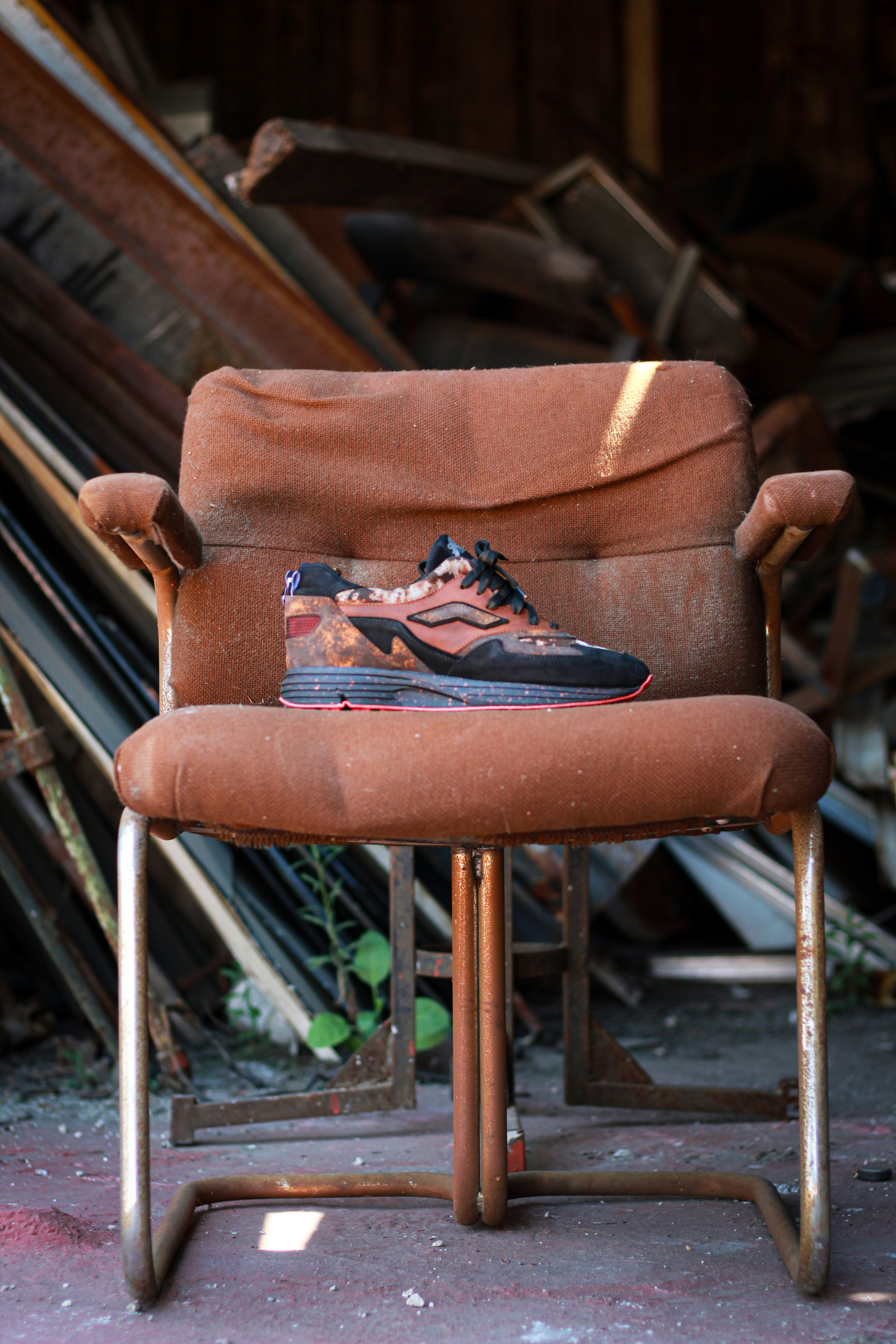 Single Sneaker on a Timeworn Armchair Amid a Junkyard of Wood and Rust