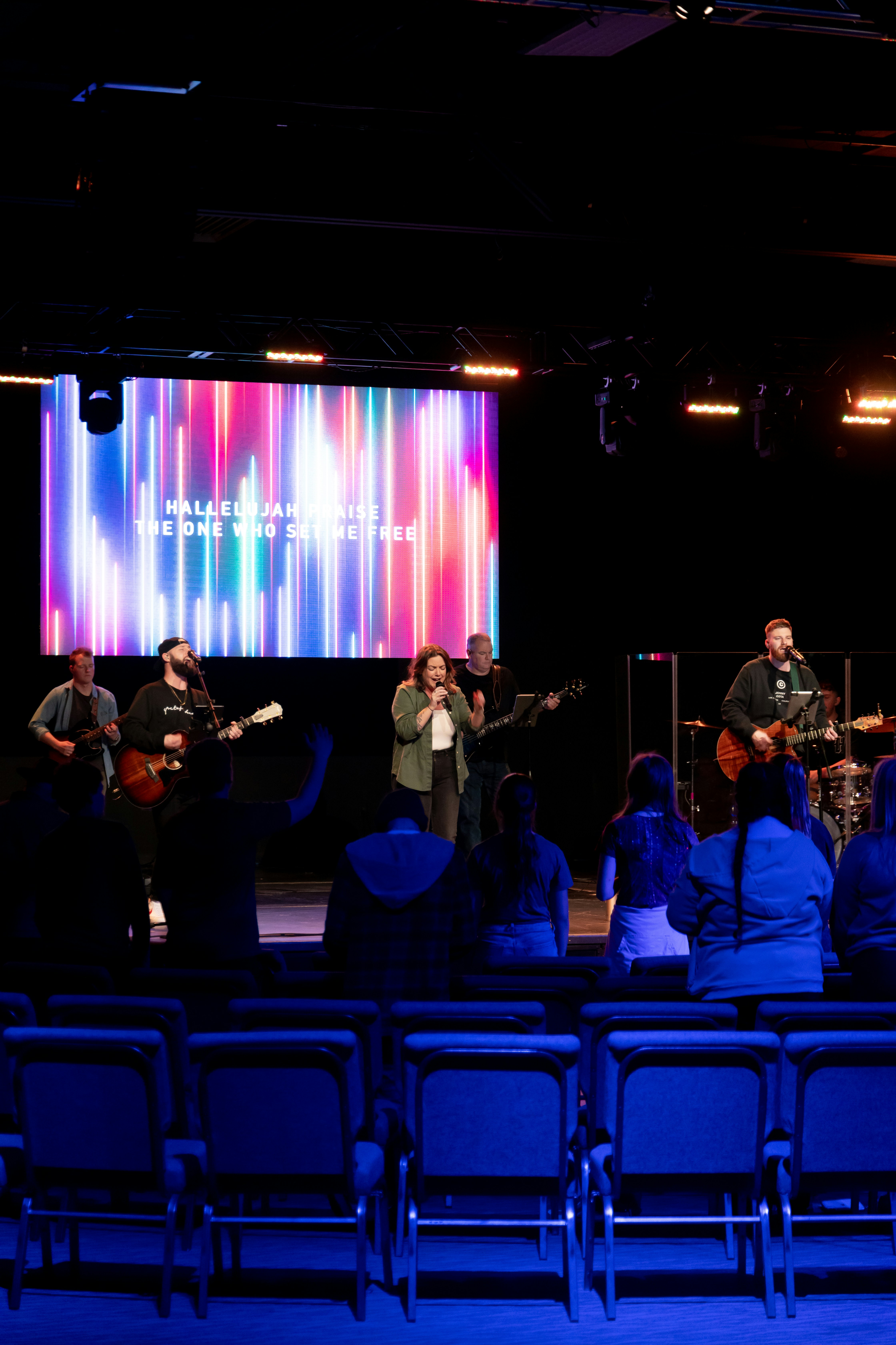 Center-Stage Vocalist Under Neon Prism in a Live Worship Set