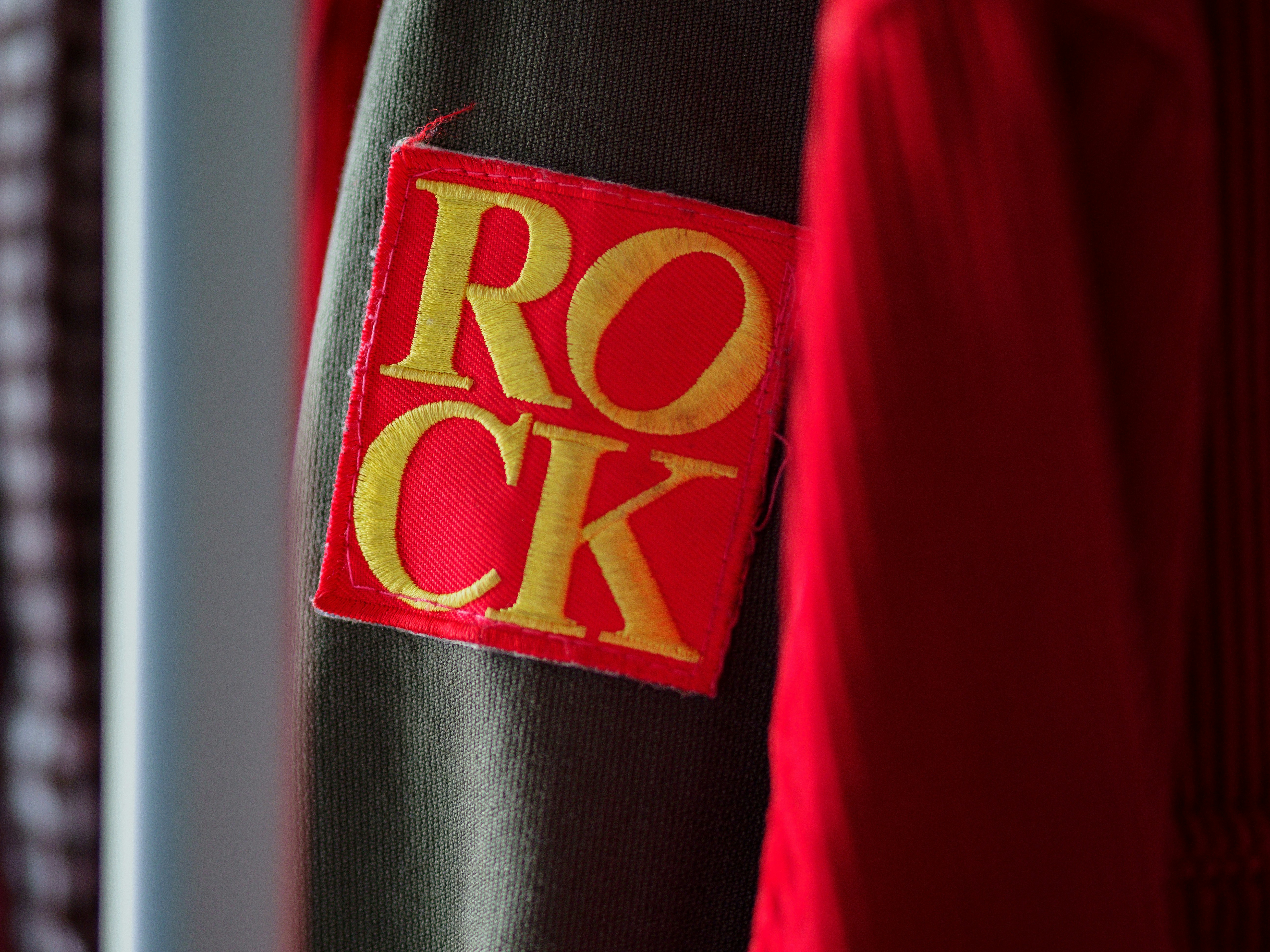 Rock Patch on Dark Fabric: A Bold Red-Gold Logo Emblem