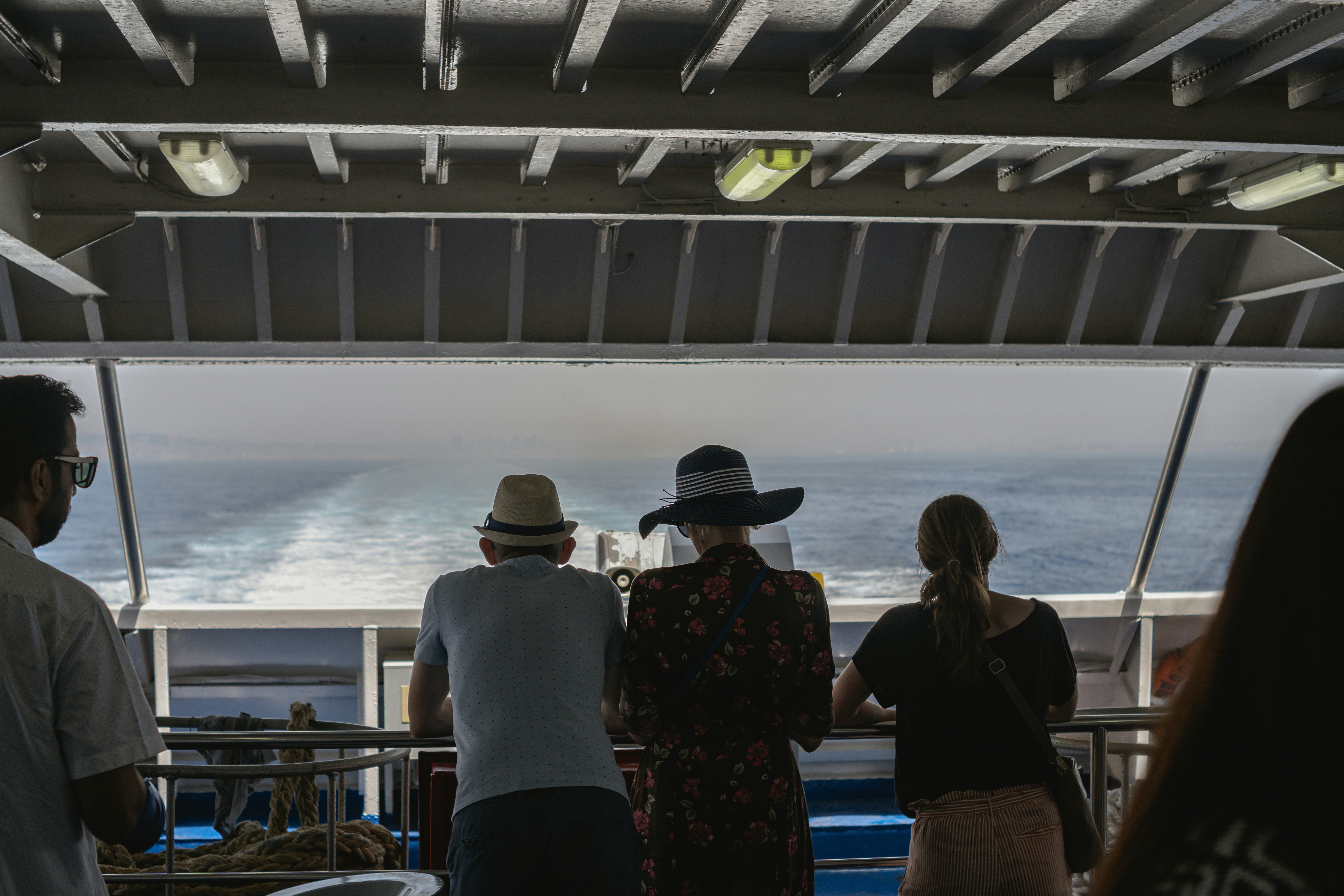 Crew on a Ferry Balcony: Backlit Ocean Trail