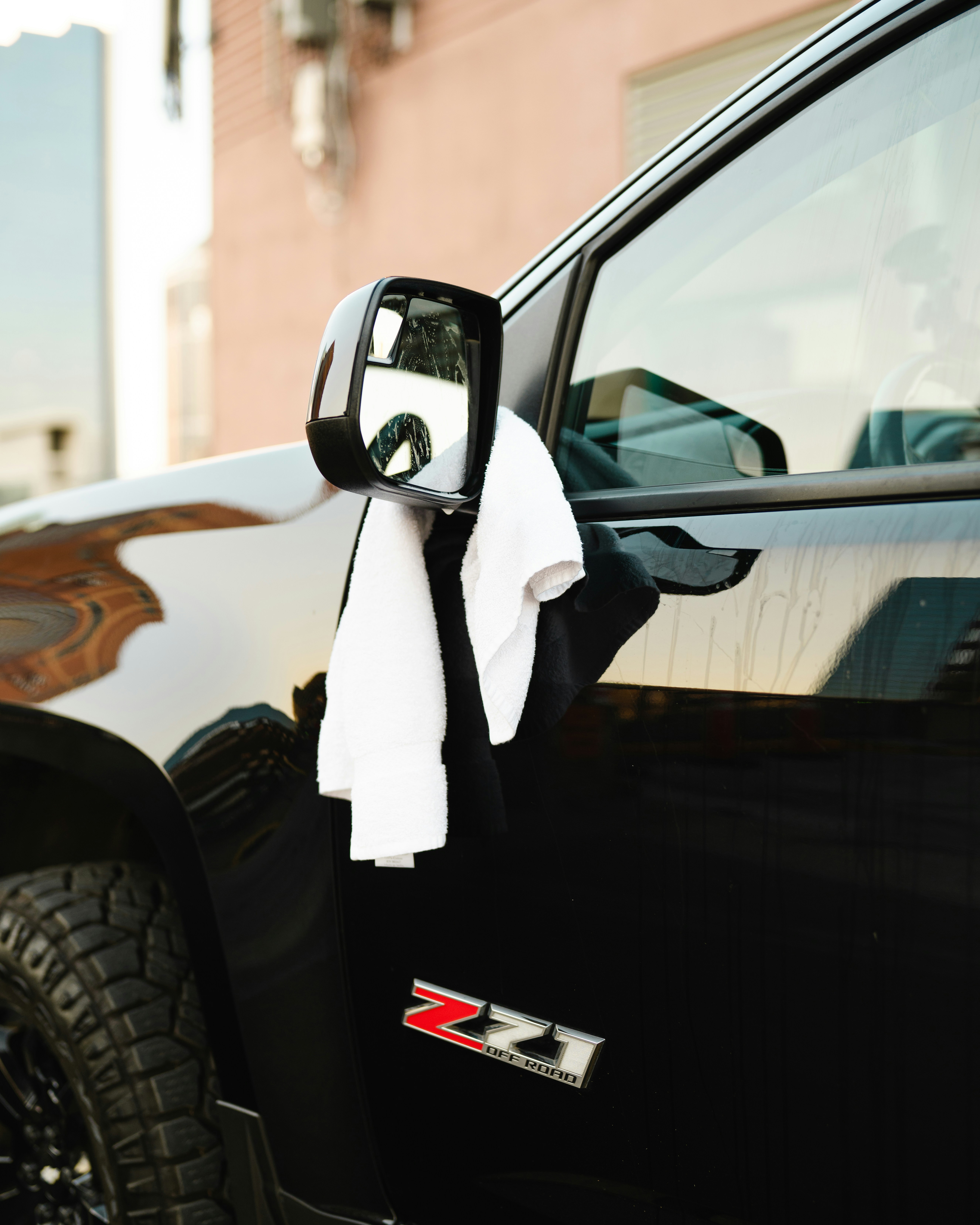 Glossy Pickup Mirror: A Towel-Draped Moment on the Driver’s Side
