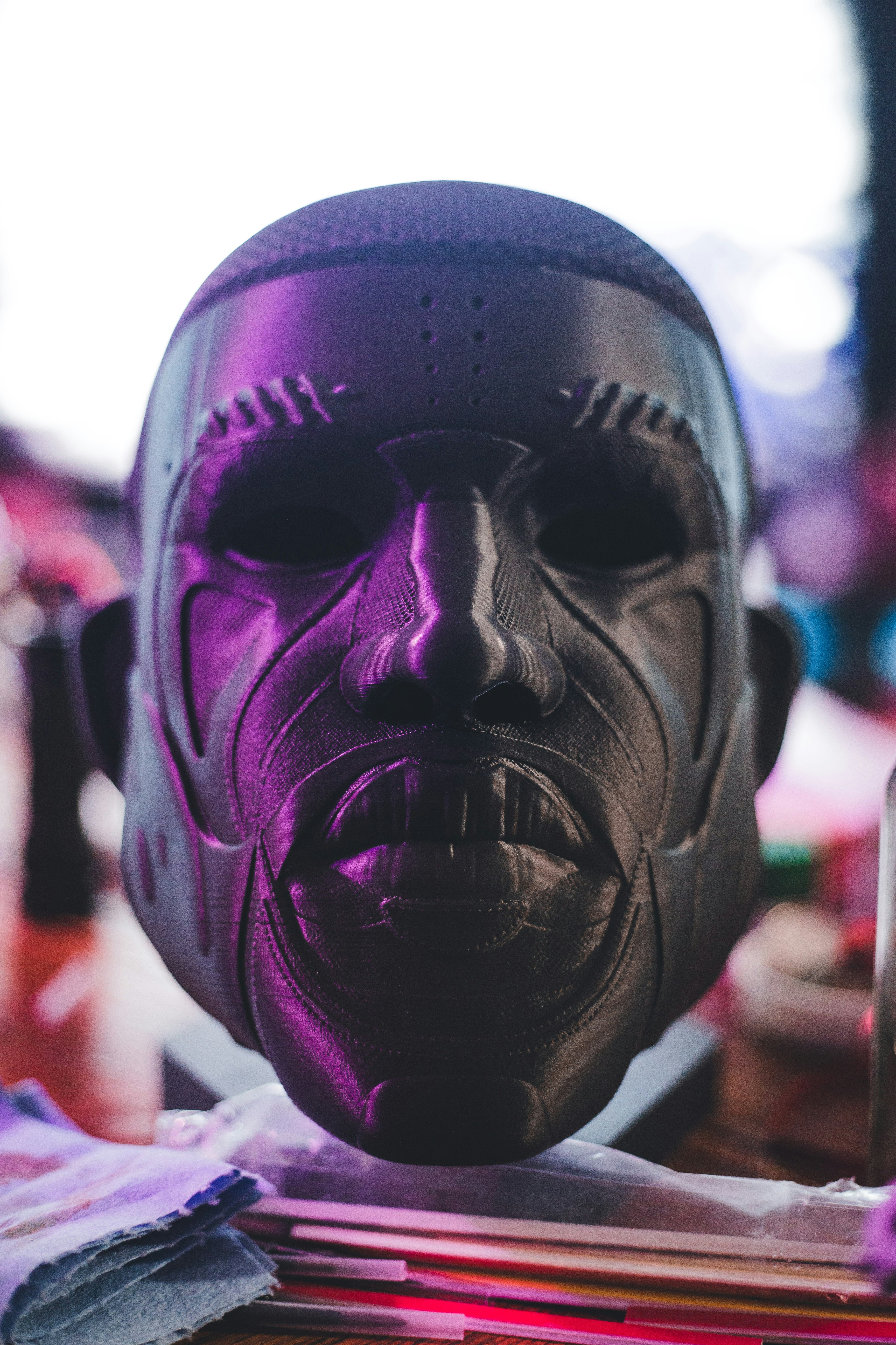 Purple-tinged mask portrait: a carved face in focus