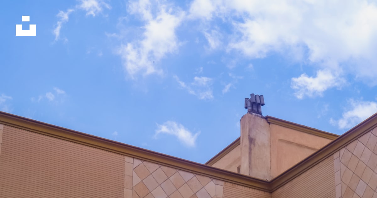 煙突と青い空を背景にした屋根の写真 Unsplashの無料ハマダーン写真