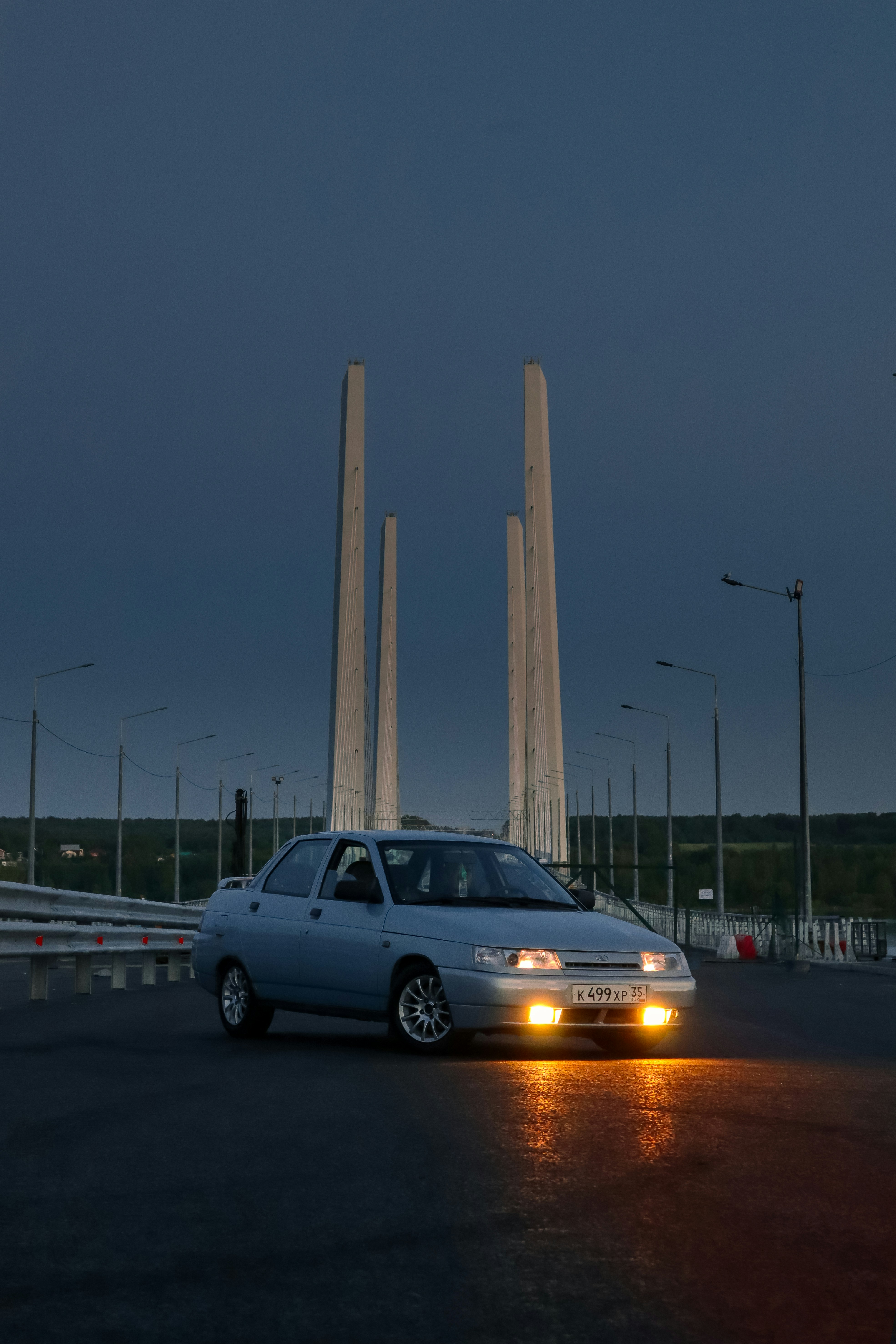 Blue-hour Bridge Crossing: A Dusk-blue Sedan Beneath Stately Pylon Towers