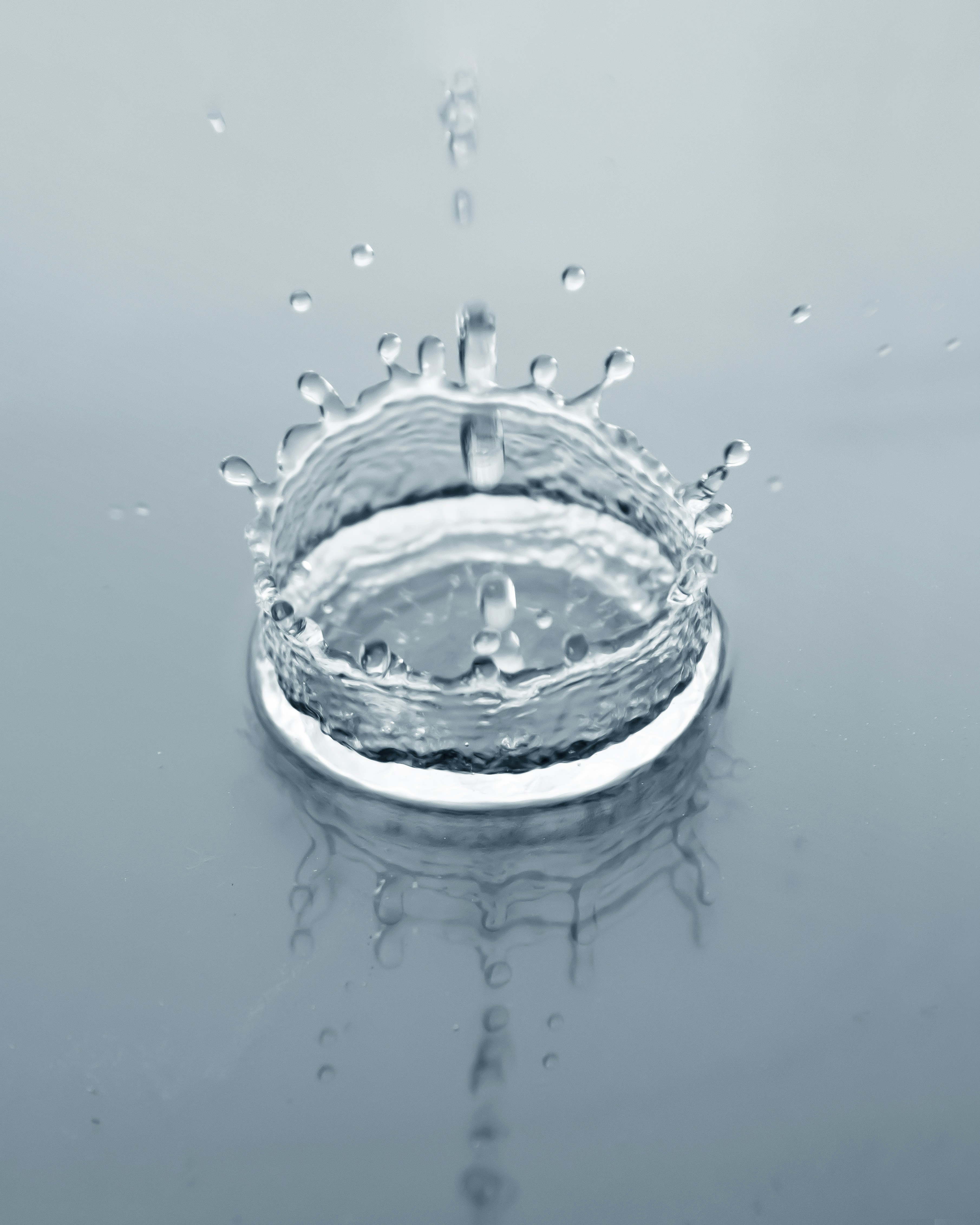 Blue Halo: A single-drop crown suspended over a glassy blue surface