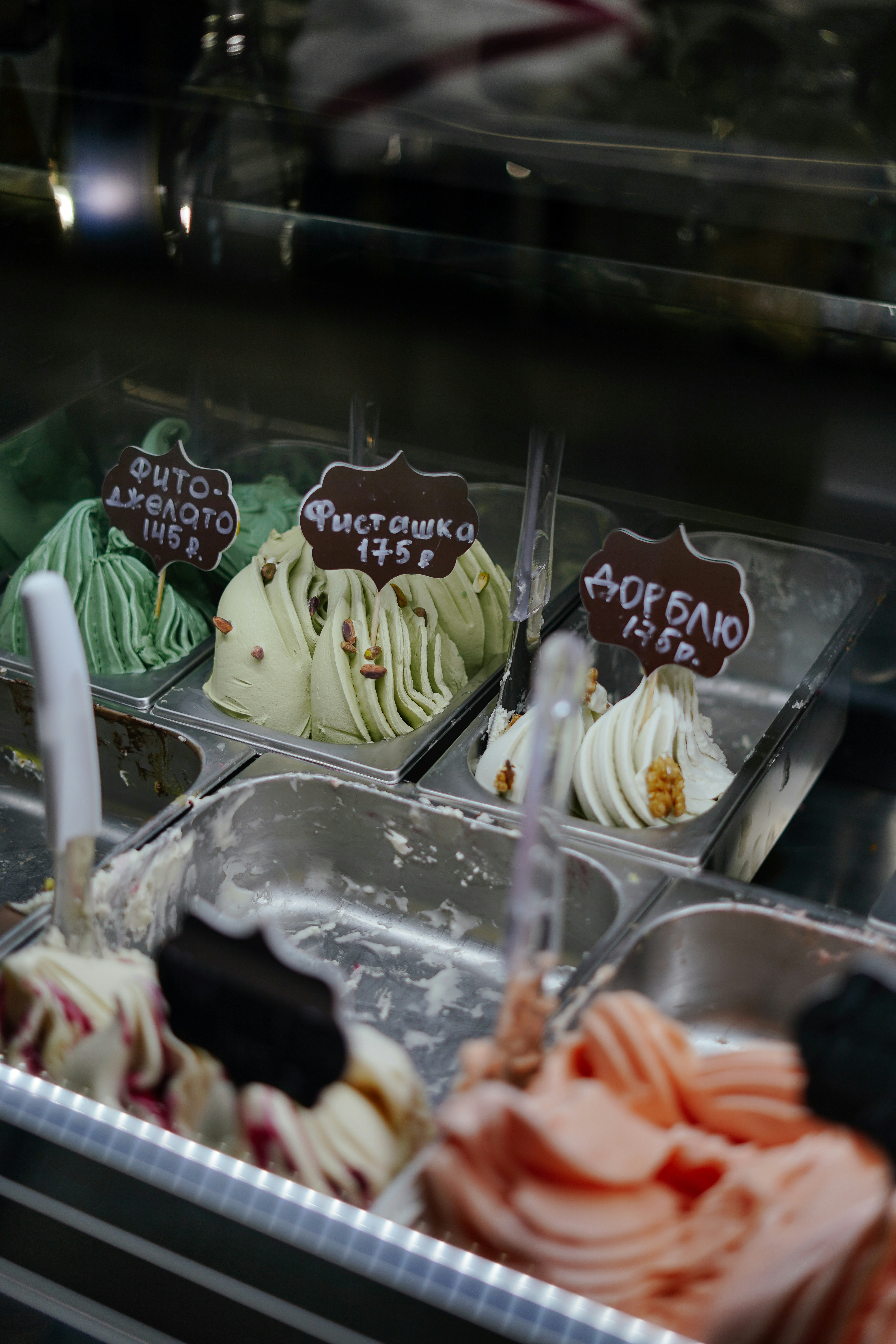 Green and Cream Gelato Rail: A Glass-Front Display of Italian Treats