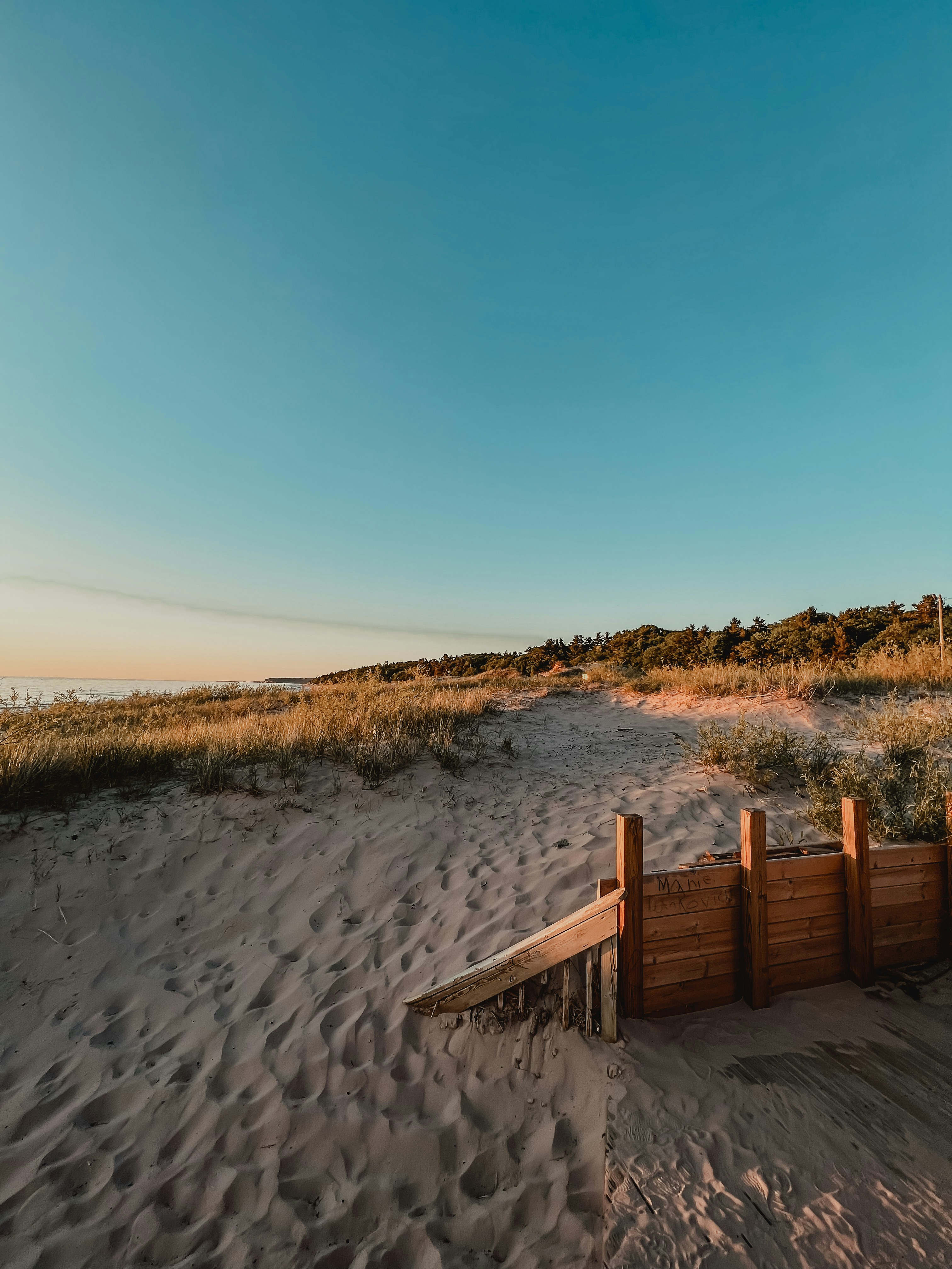 A sandy beach with a fence photo – Free Onekama Image on Unsplash