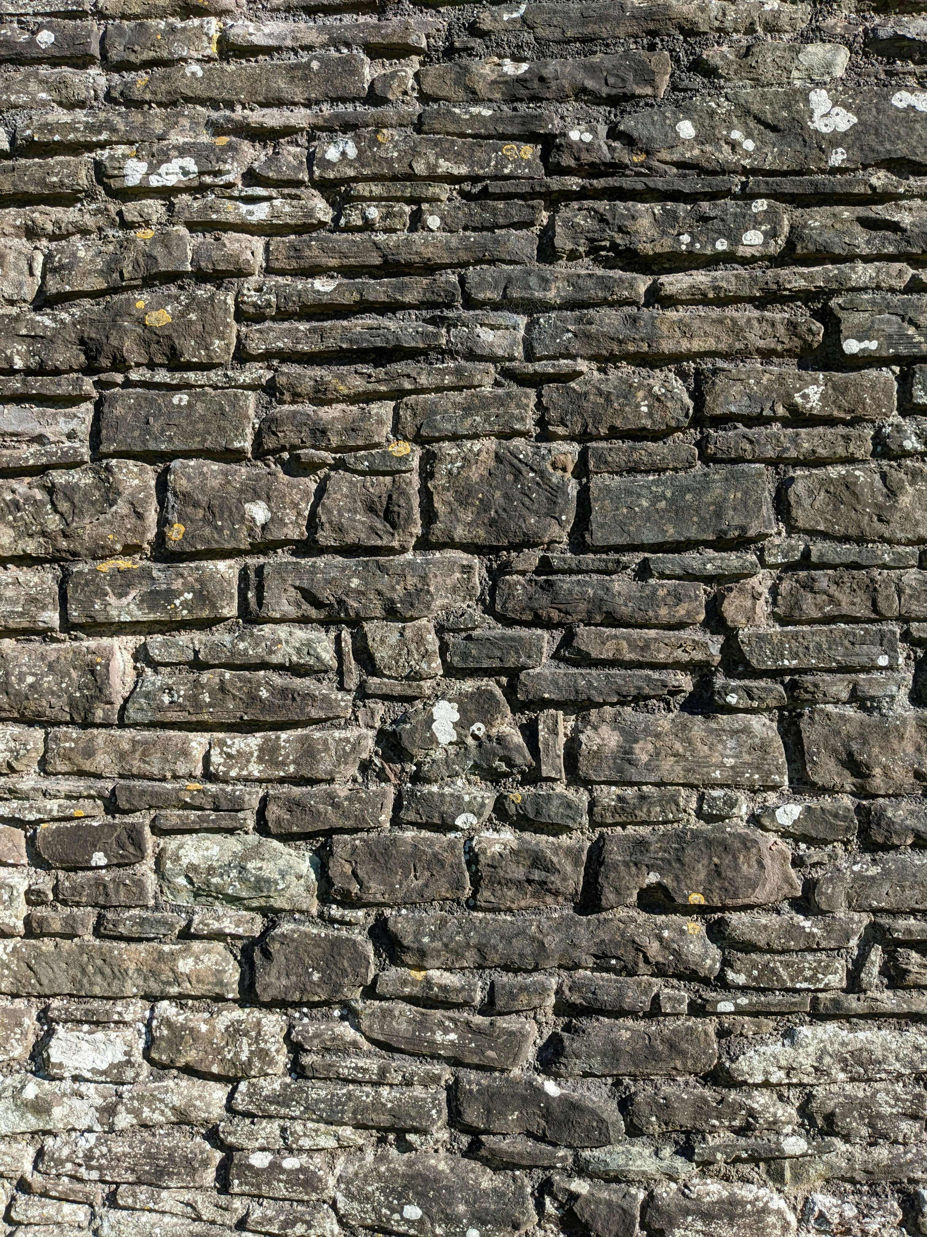Ancient castle wall at Skenfrith on the Welsh border, in Wales, UK. 
Stone background texture.

 | a brick wall with a hole in it