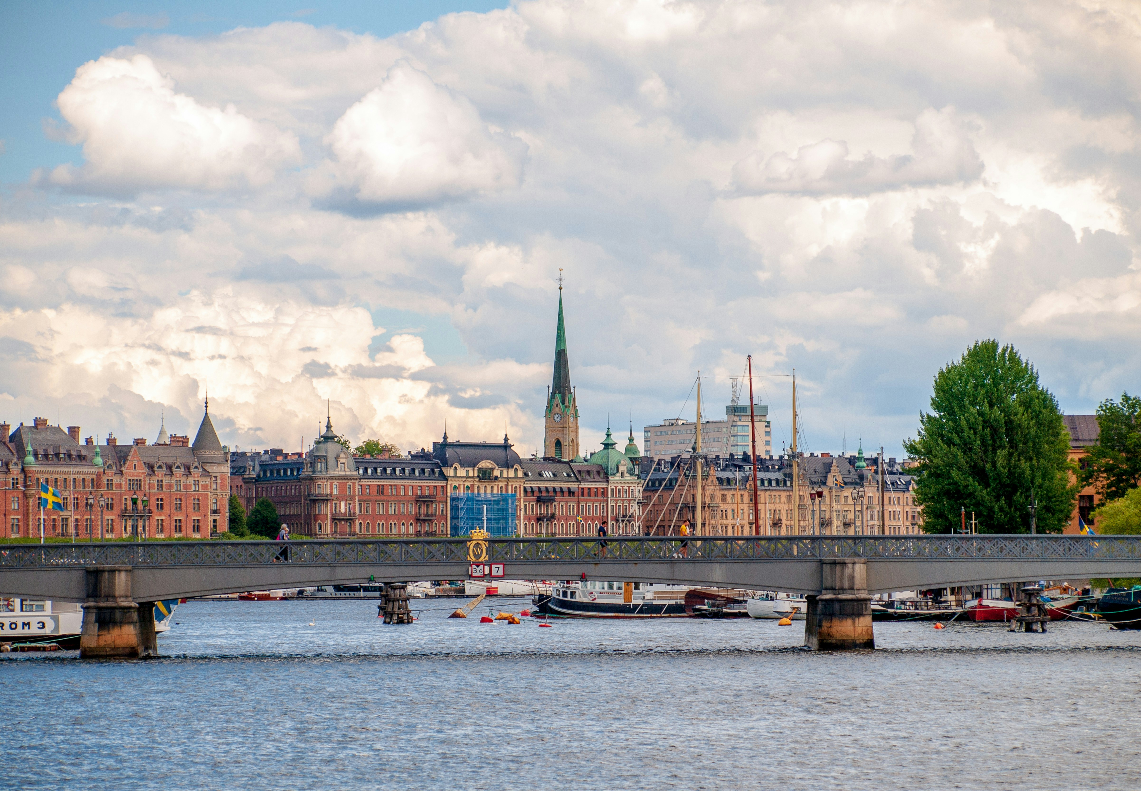 A bridge over a river with a city in the background photo – Free ...