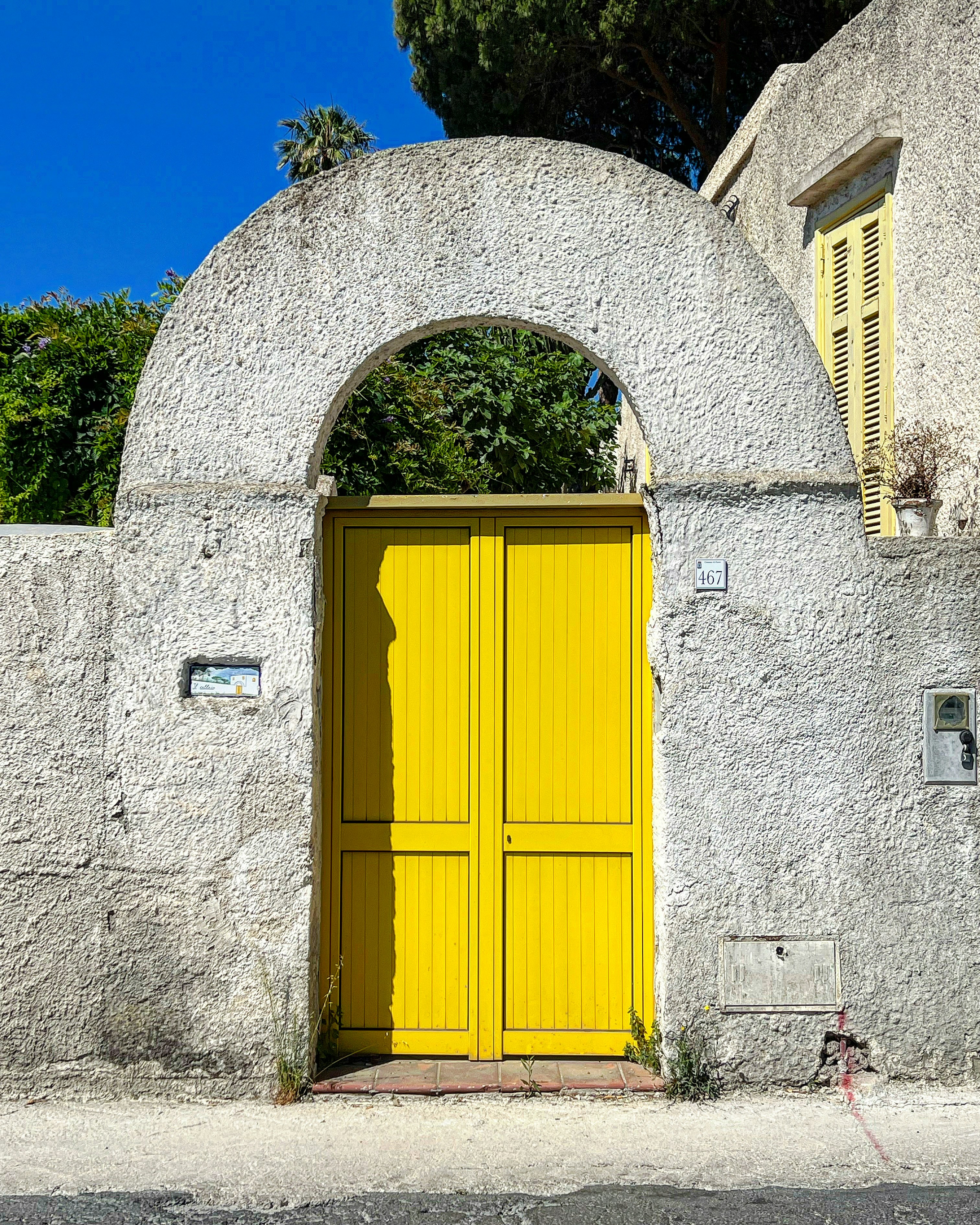 Sunlit Yellow Gate in Urban Stone Archway