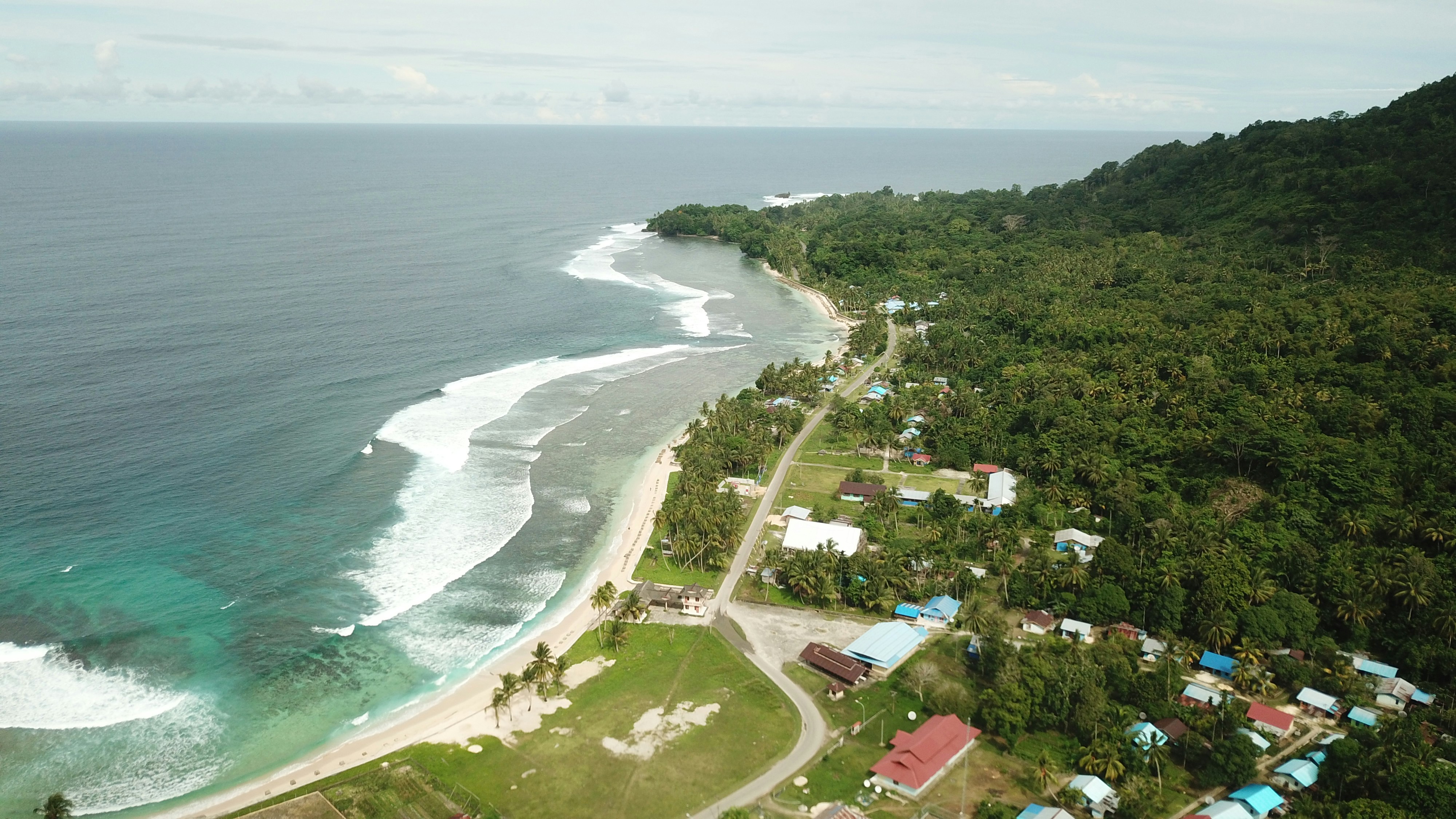A beach with houses and trees by it photo – Free Biak Image on Unsplash