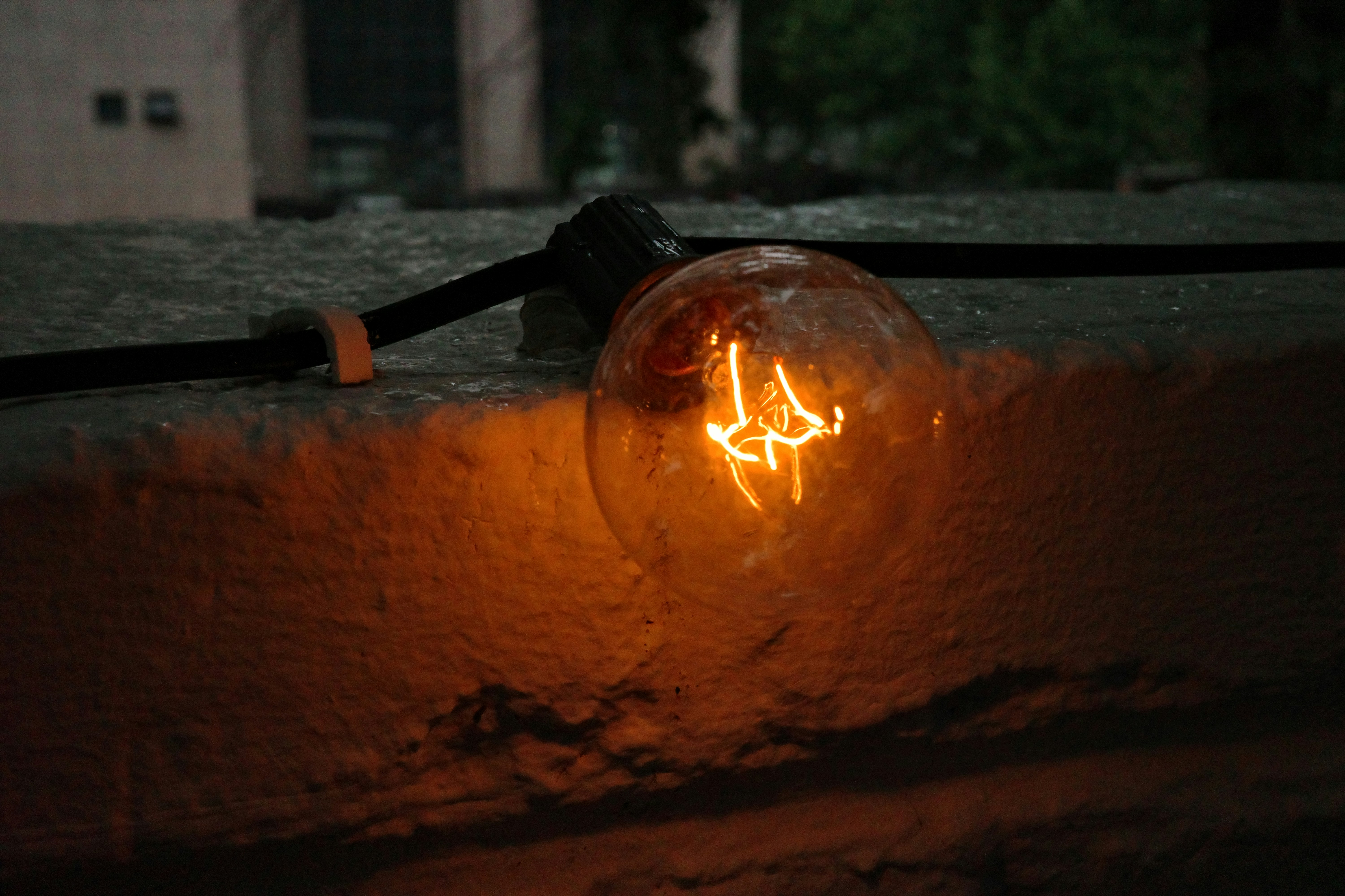 On the Edge of Night: A lone filament glow on a weathered stone ledge