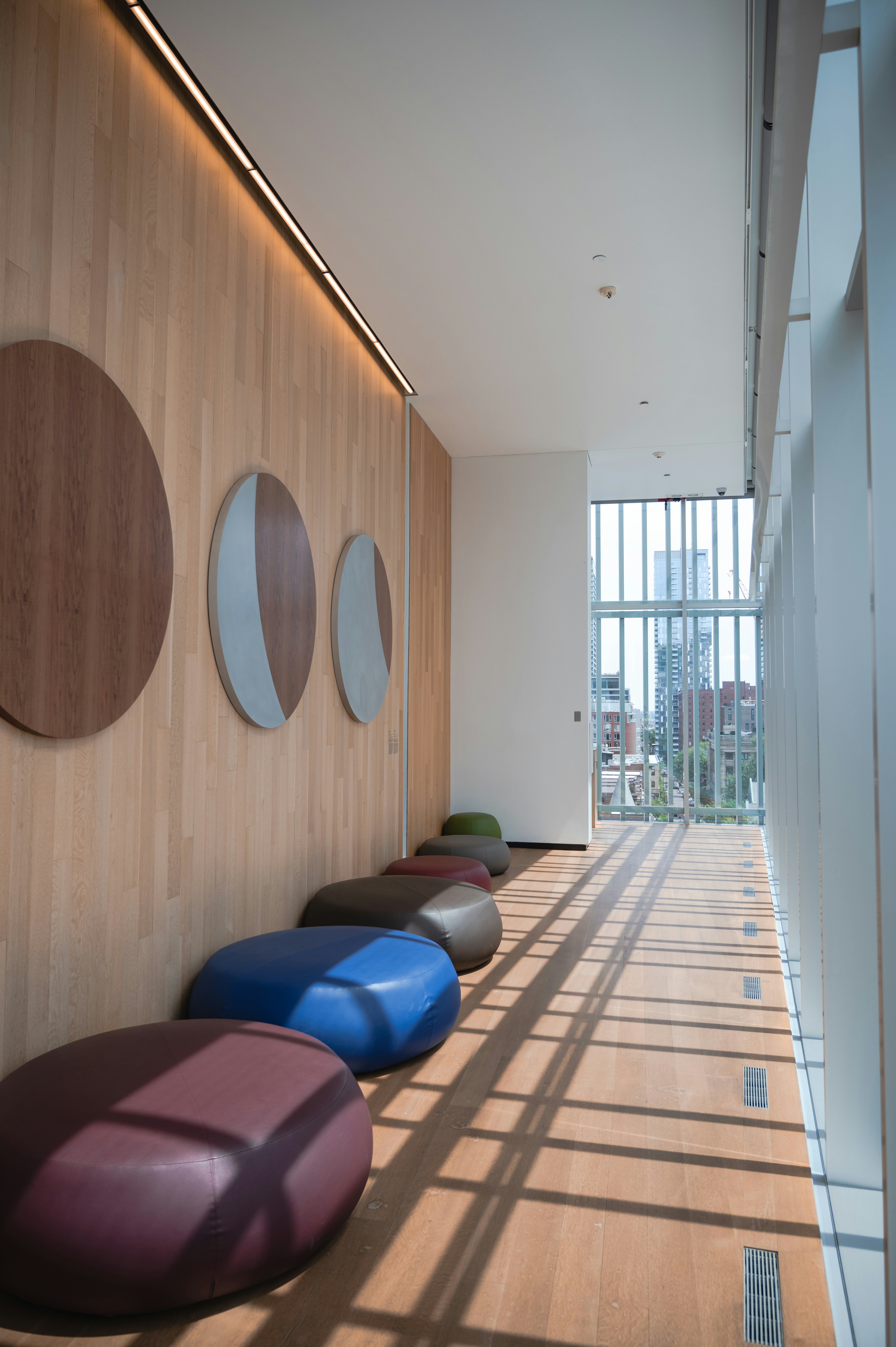 Colorful bean seating along sunlit modern corridor