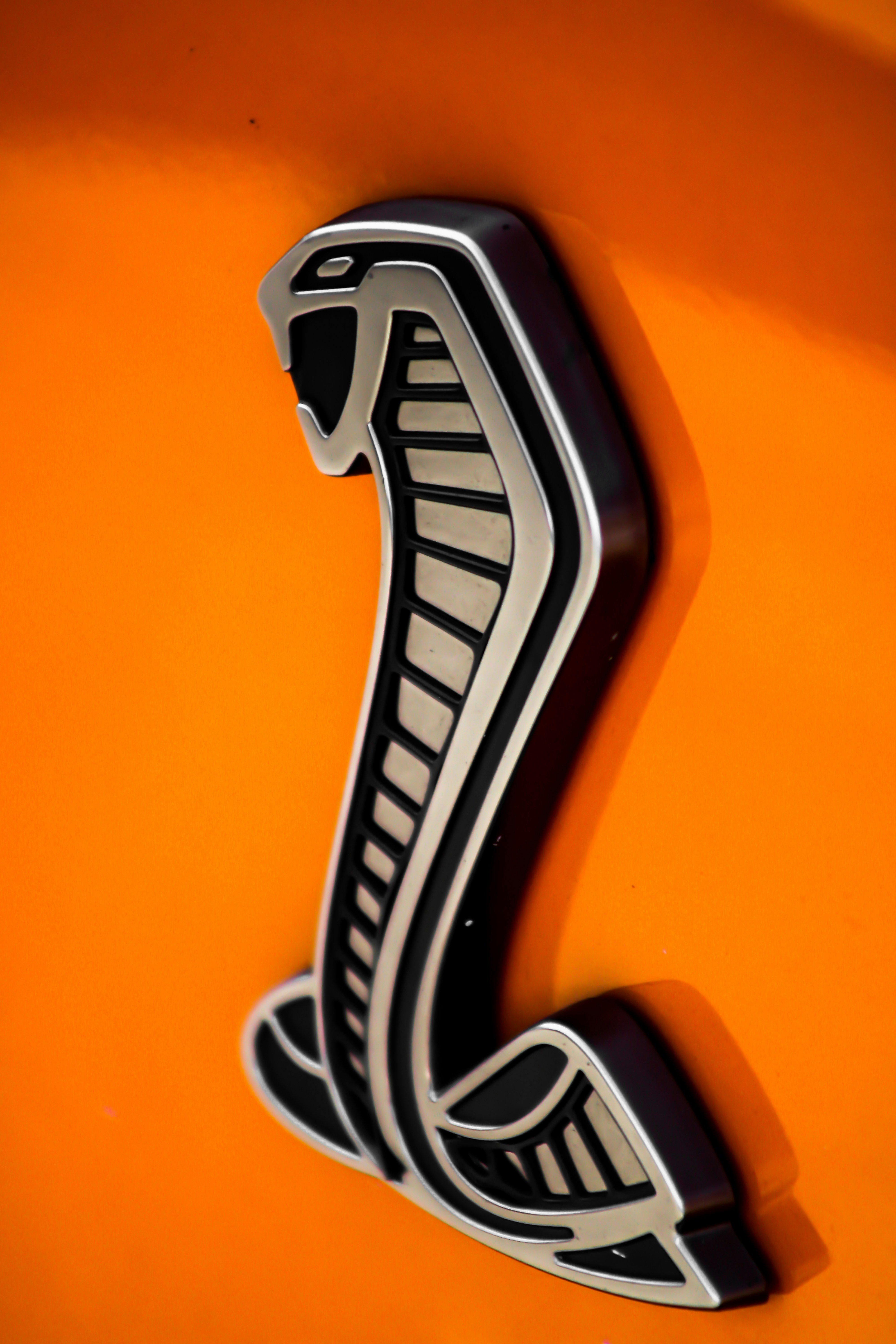 L-Shaped Chrome Badge Anchored on a Fiery Orange Panel