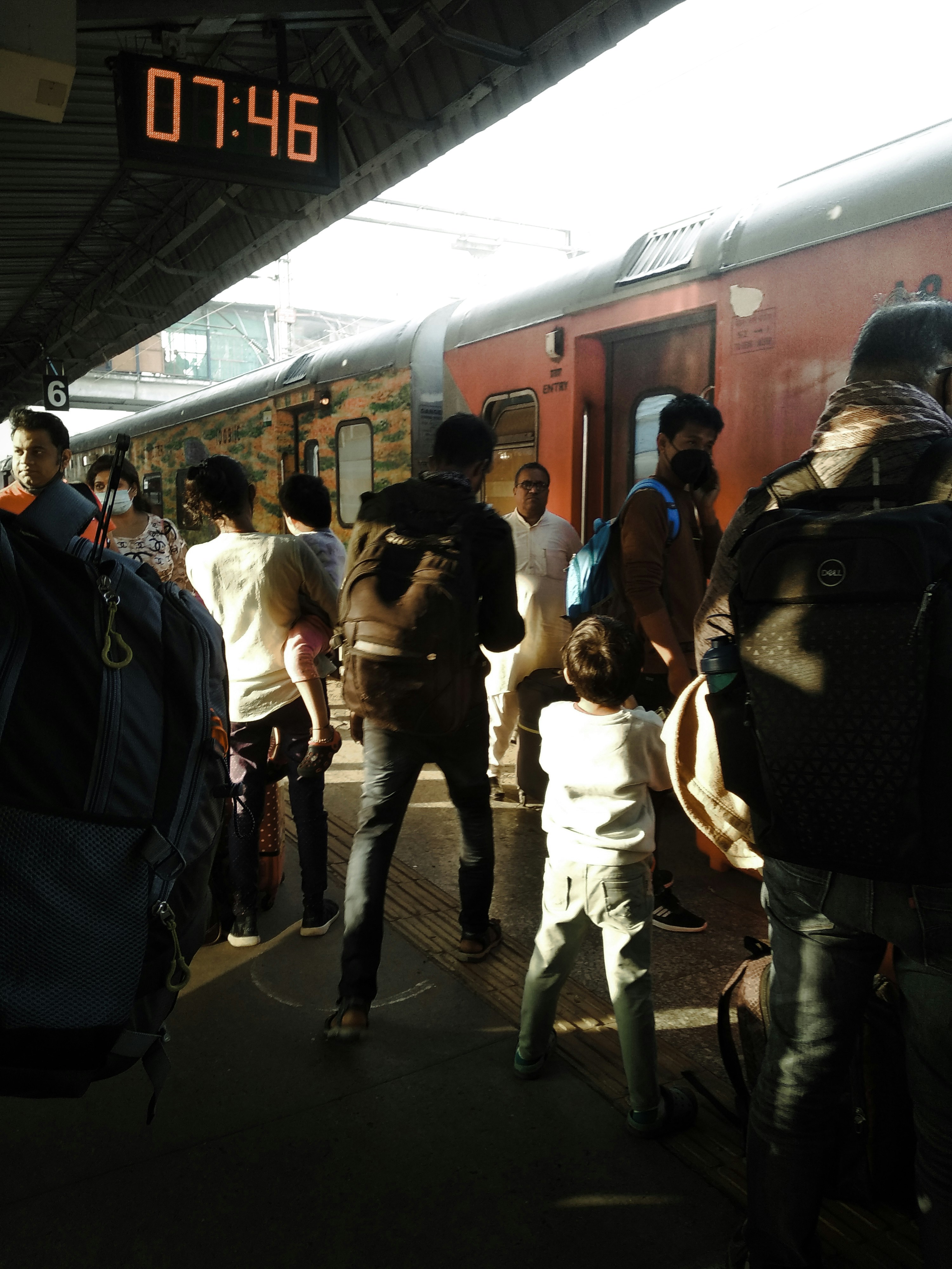 Busy train station scene with commuters boarding a train as a clock displays the time. The atmosphere captures the essence of daily travel.