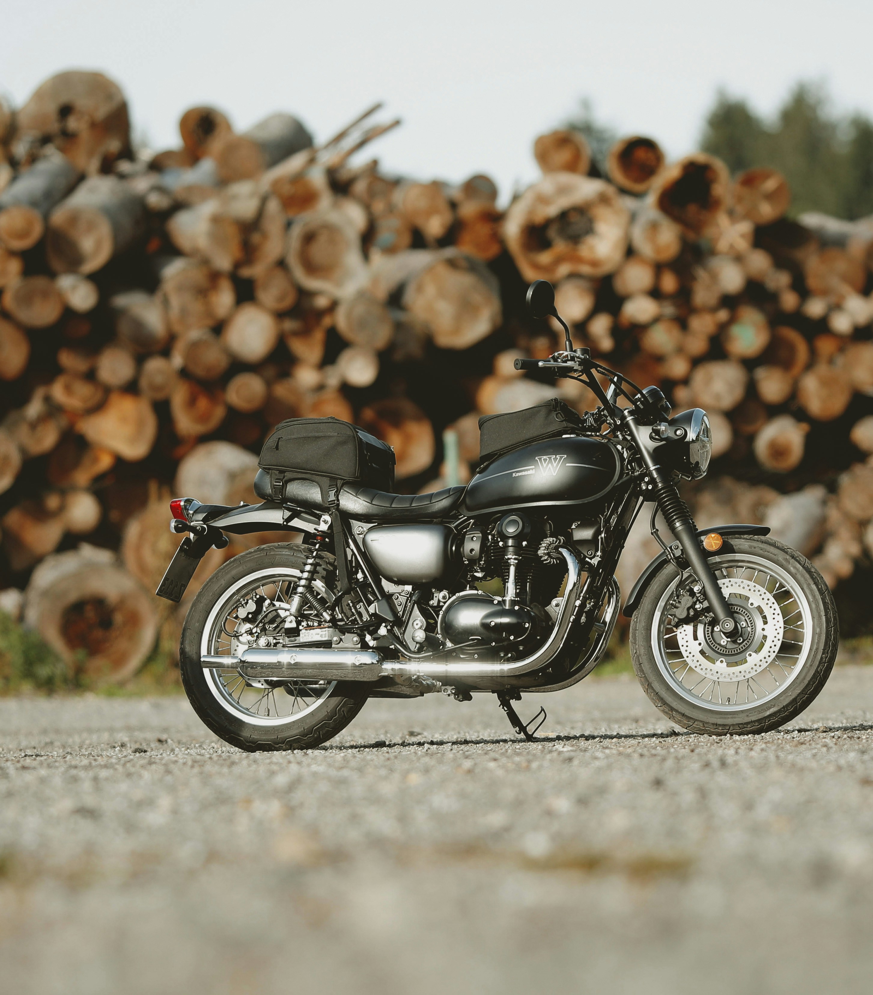 A motorcycle parked in front of a pile of logs photo – Free Motorcycle ...