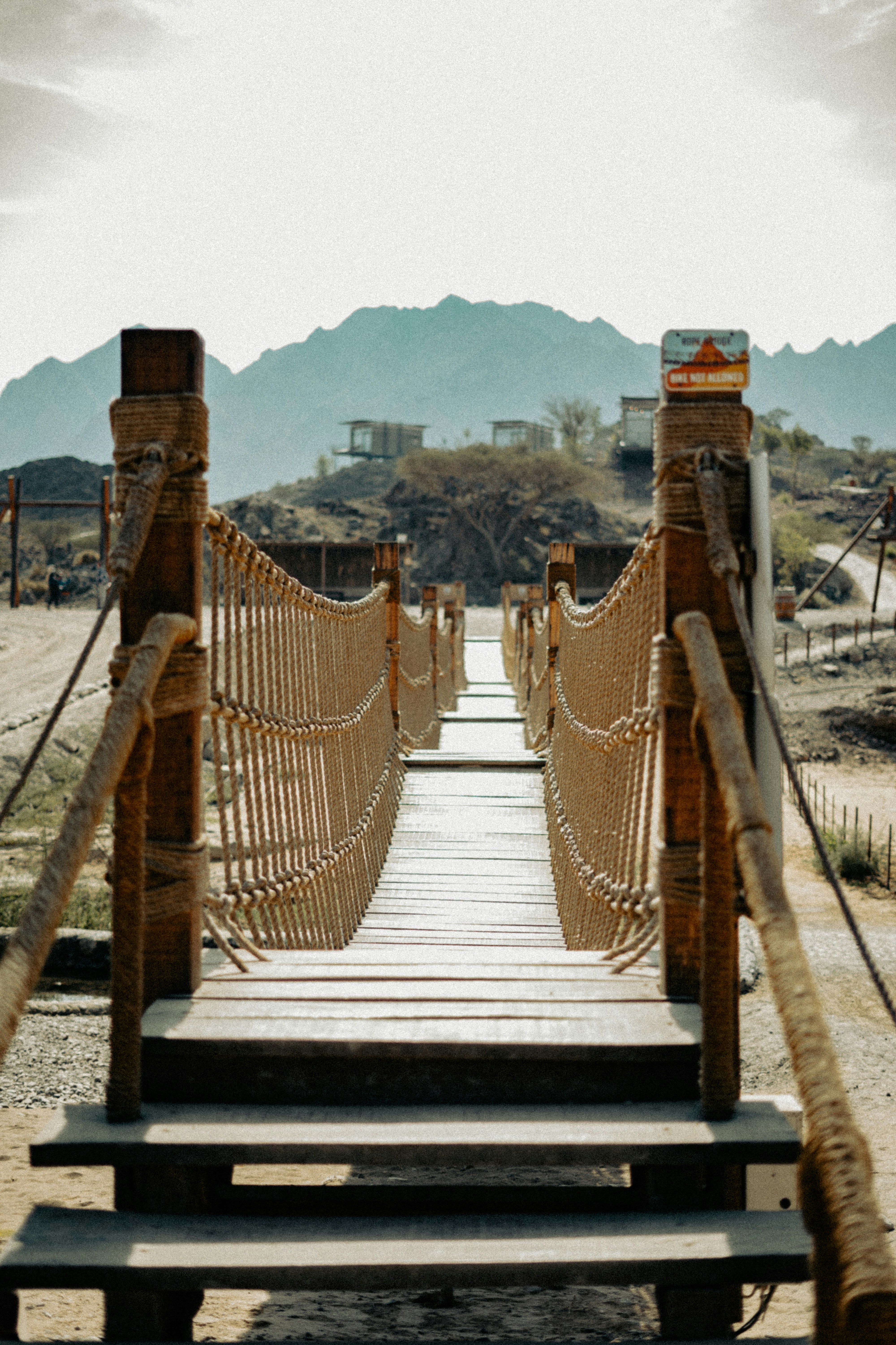 Bridge of Light and Sand: A Narrow Walk Toward the Distant Peaks