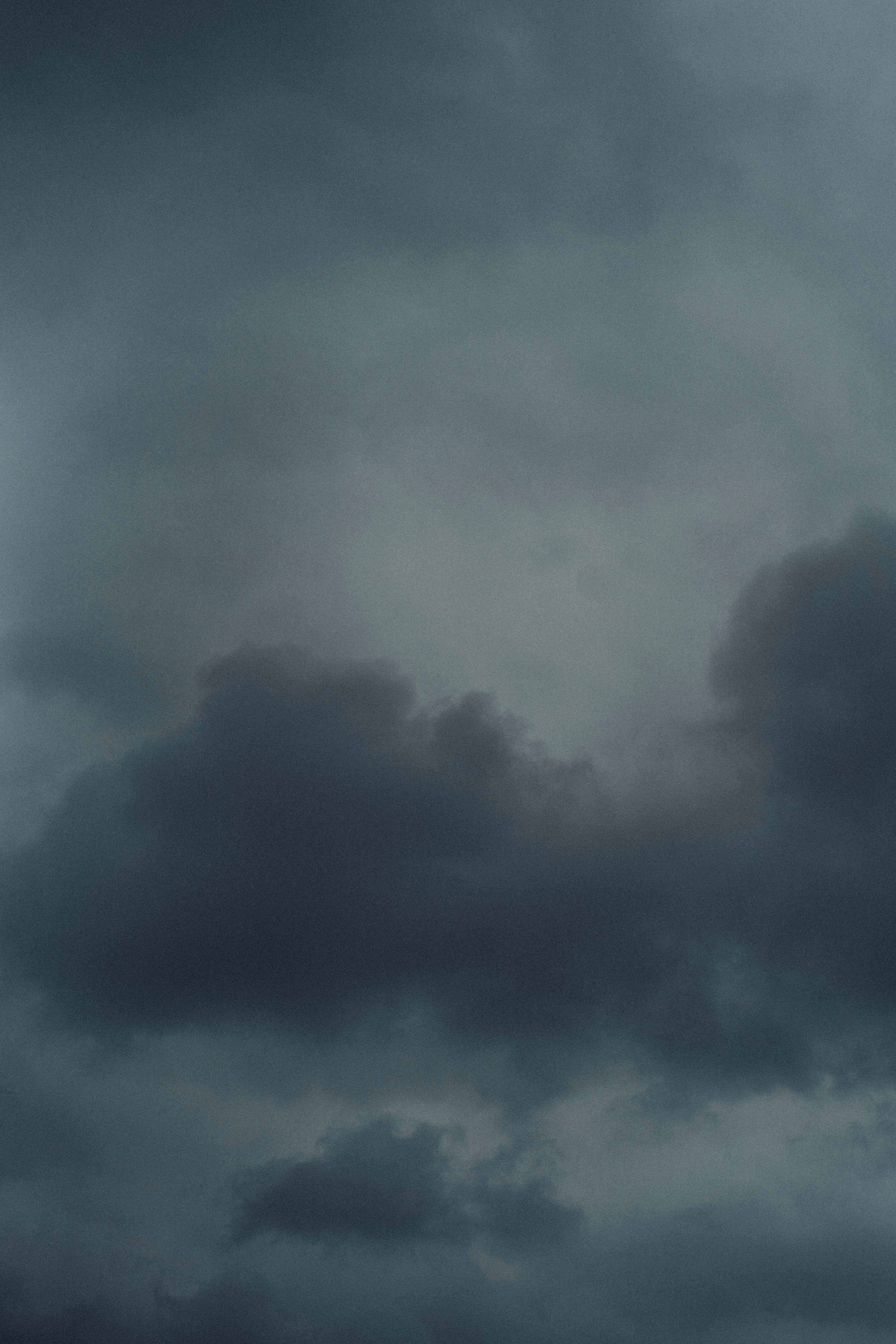 Dramatic cloud formations fill the sky, hinting at an impending storm. The moody atmosphere evokes a sense of anticipation.