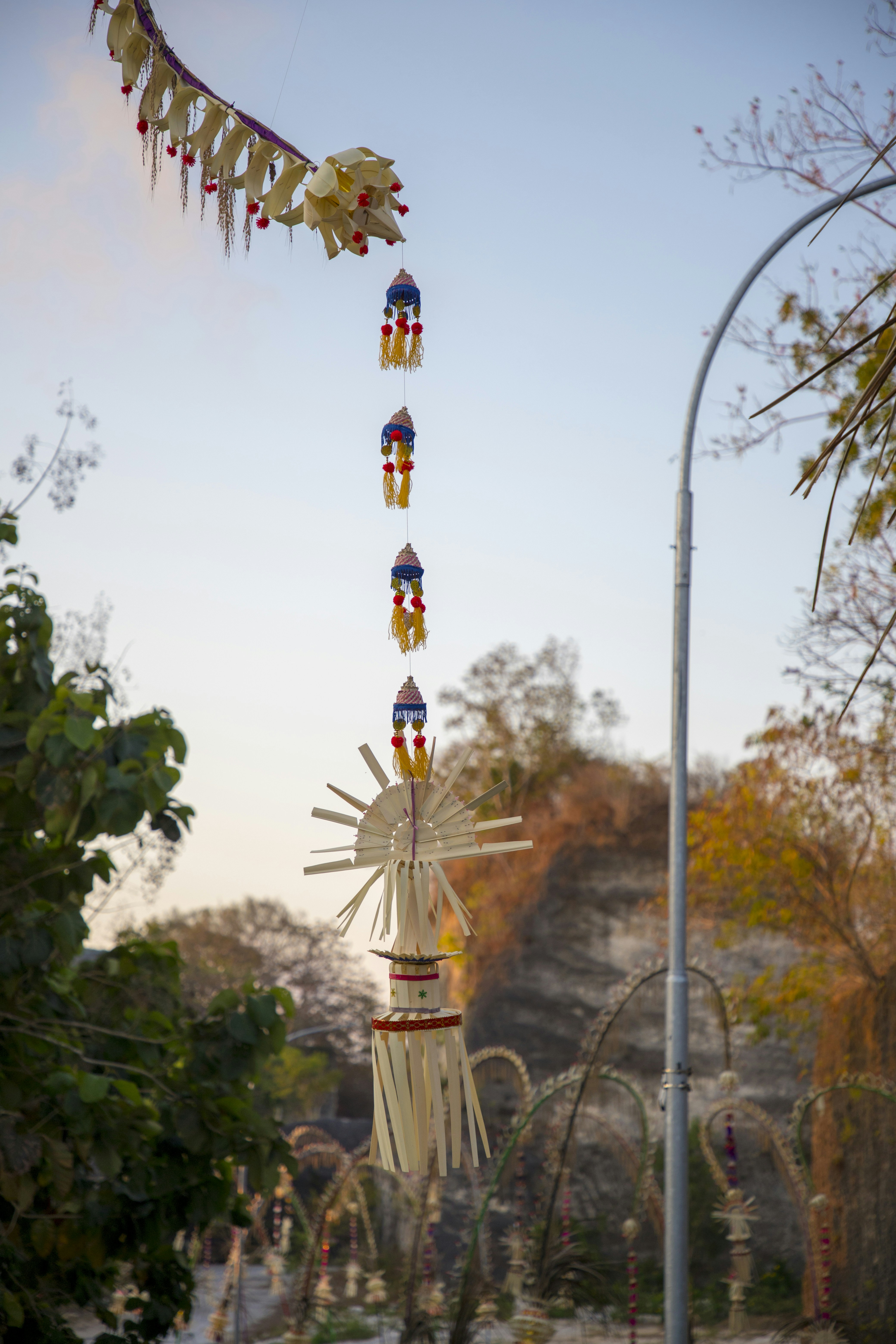 Vertical String of Paper Ornaments Reaching Toward a Quiet Sunset