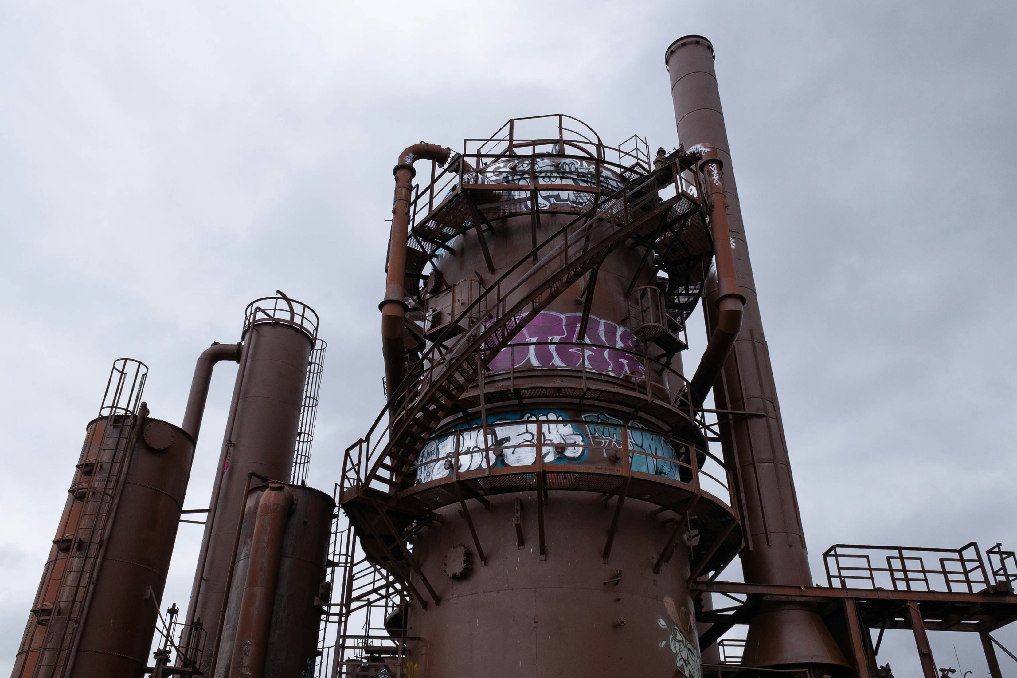 Rust-Colossus Under a Clouded Sky: A Weathered Refinery Tower