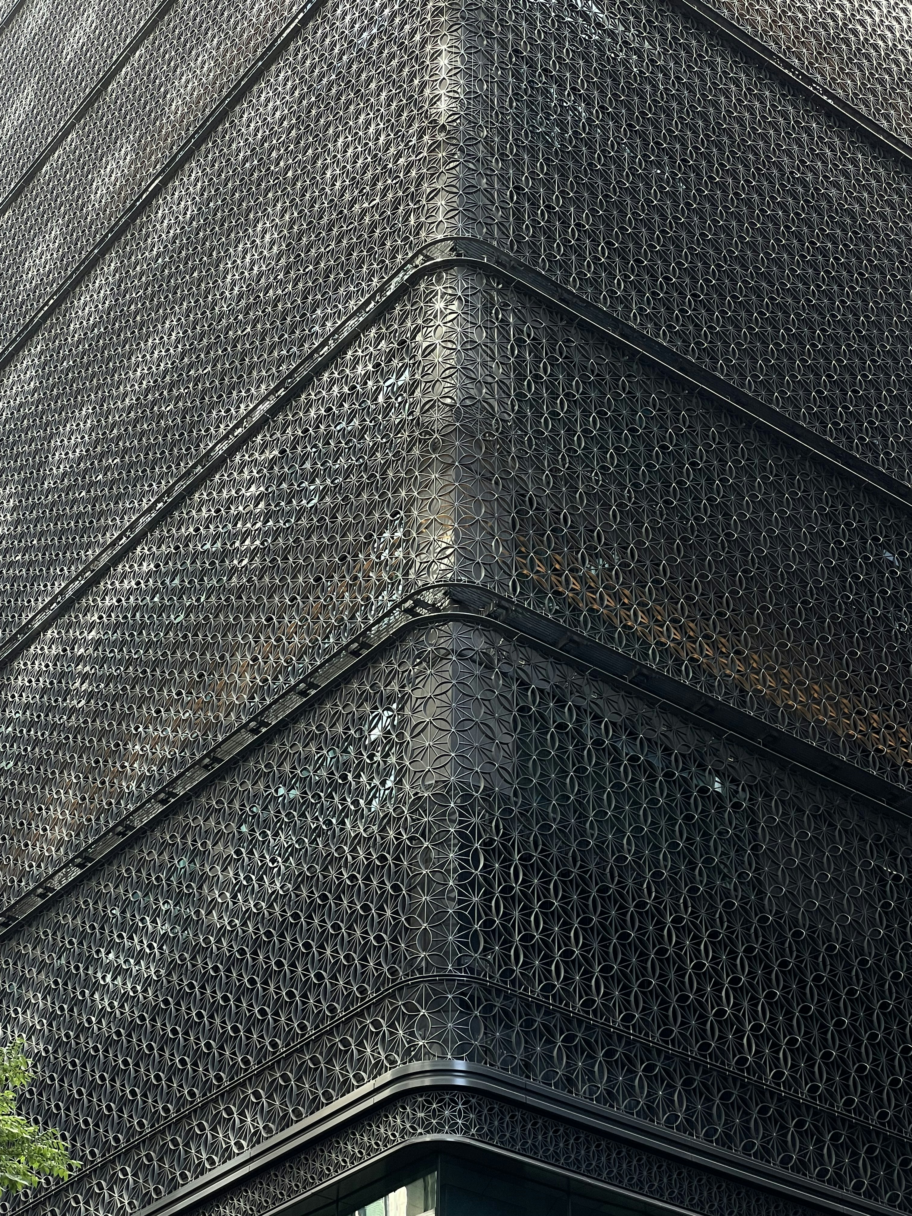 Intricate facade of a modern building showcasing a unique pattern of interlocking shapes. The design emphasizes both artistry and structural sophistication.