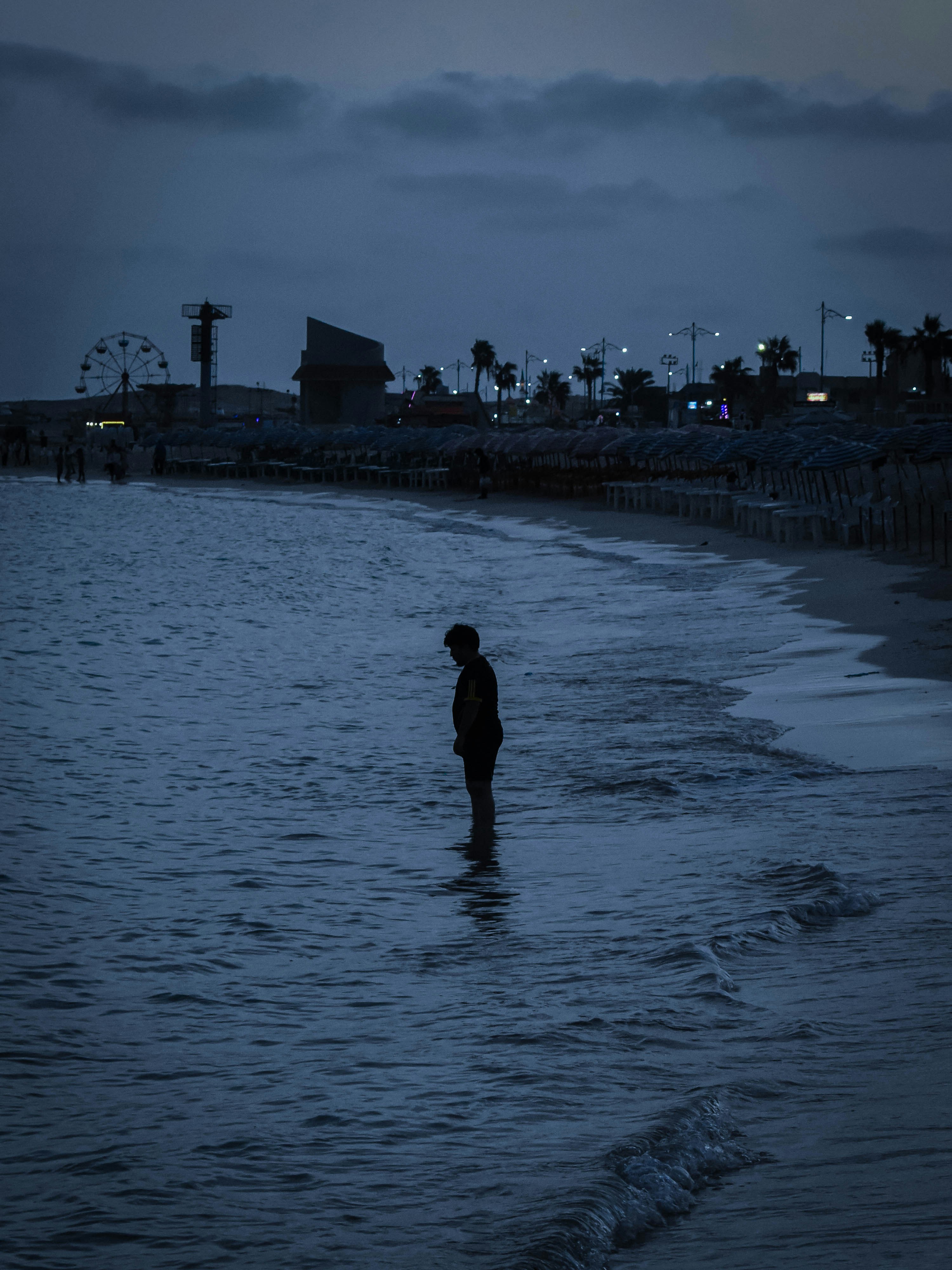 Solitary Figure at Dusk: Shoreline Silhouette by the Quiet Sea