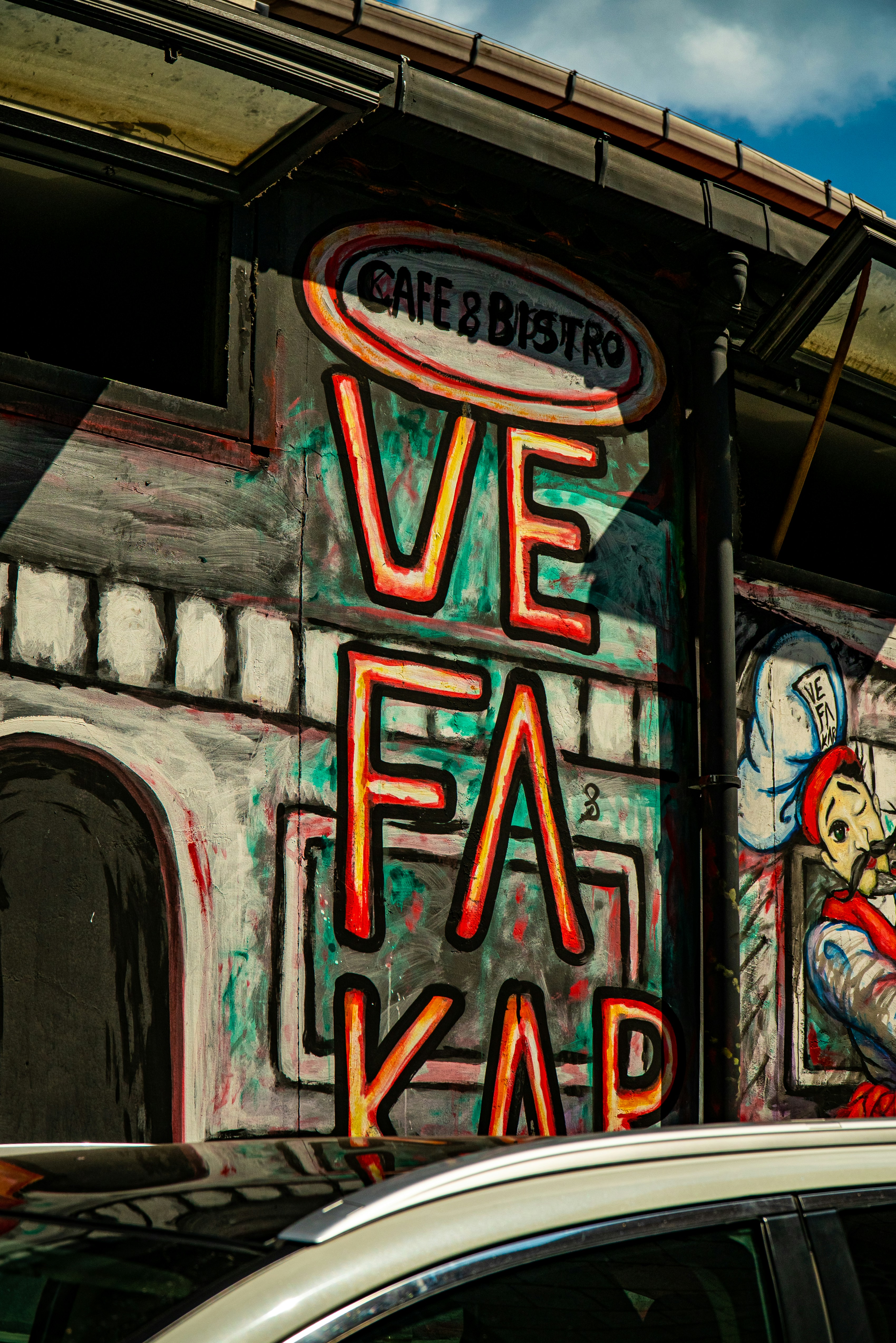 Vertical Neon on a Graffiti Café Wall