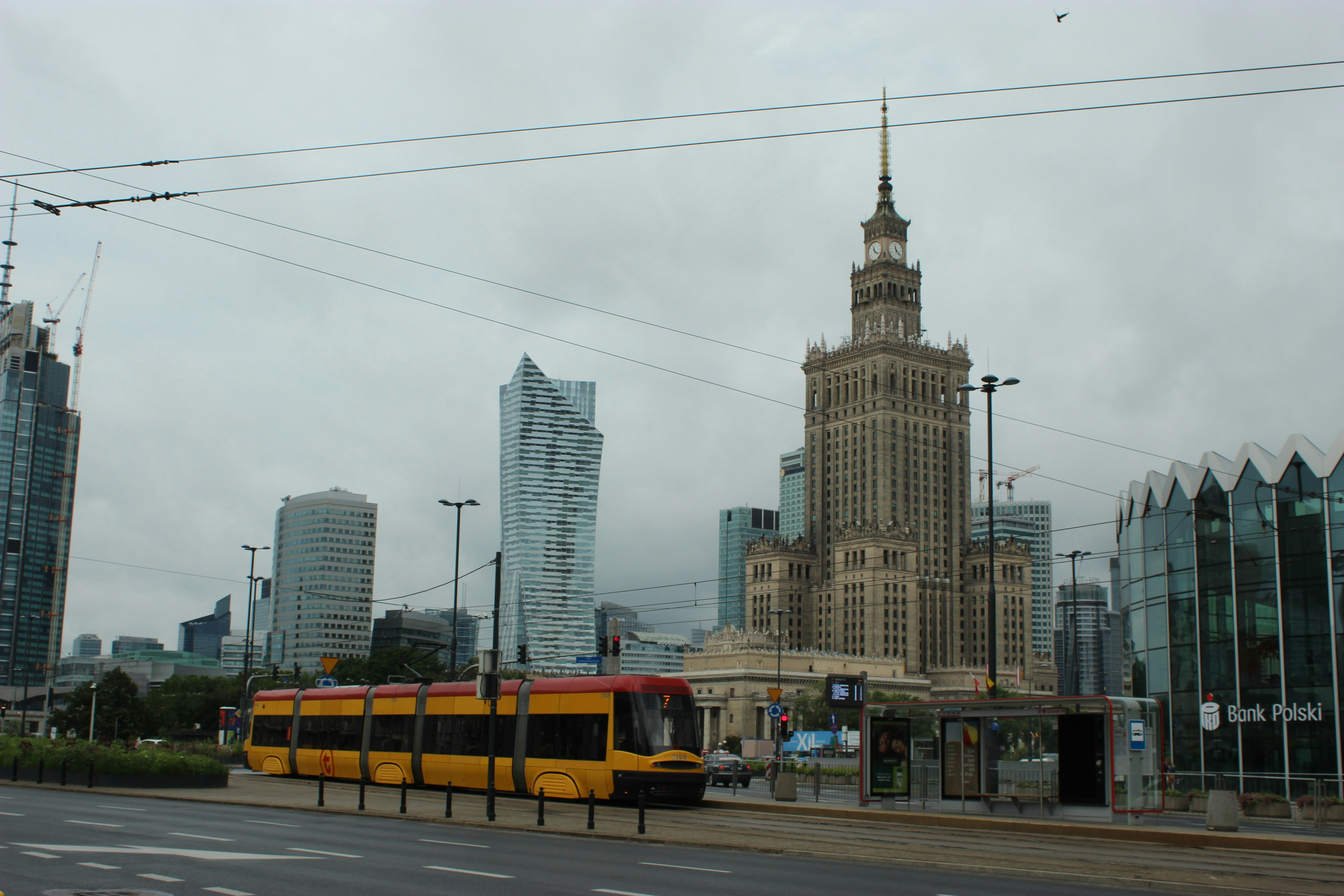 Tram gliding past the iconic Palace of Culture and Science amidst a backdrop of contemporary architecture in Warsaw.