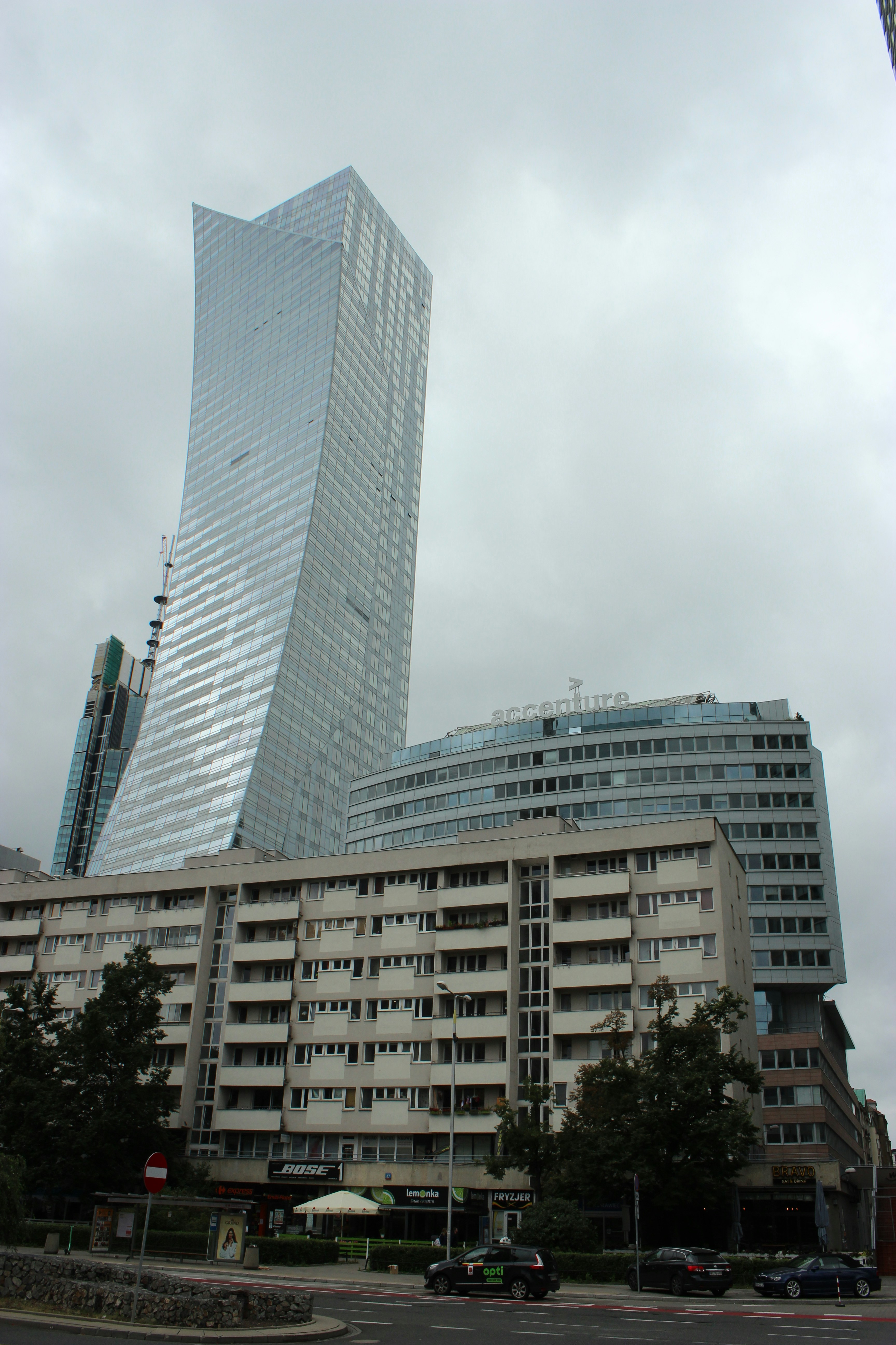 Tilted Glass Spire Dominates a Layered Cityscape