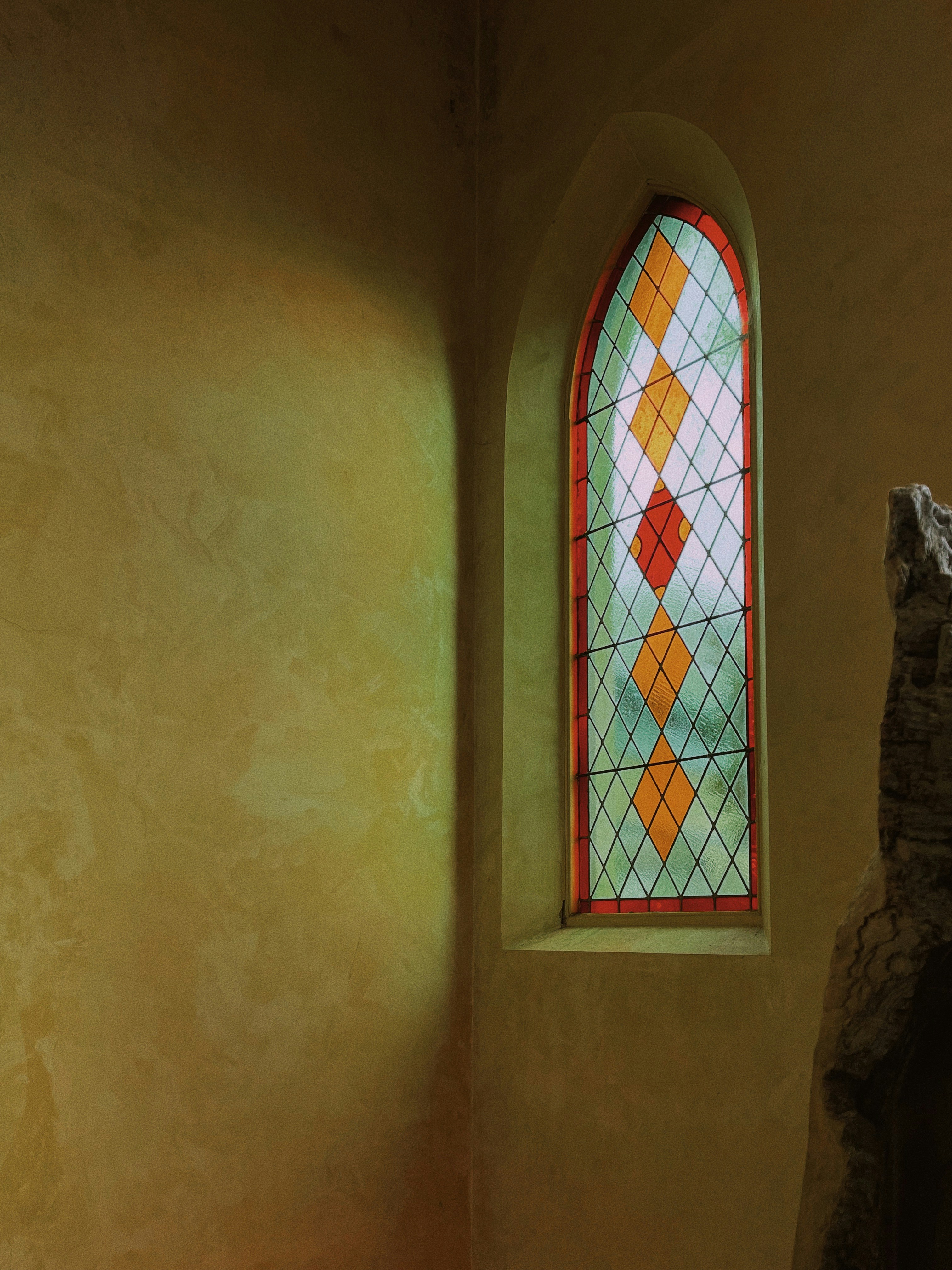 Amber Diamonds: Light Filtering Through a Diamond-Patterned Arch Window
