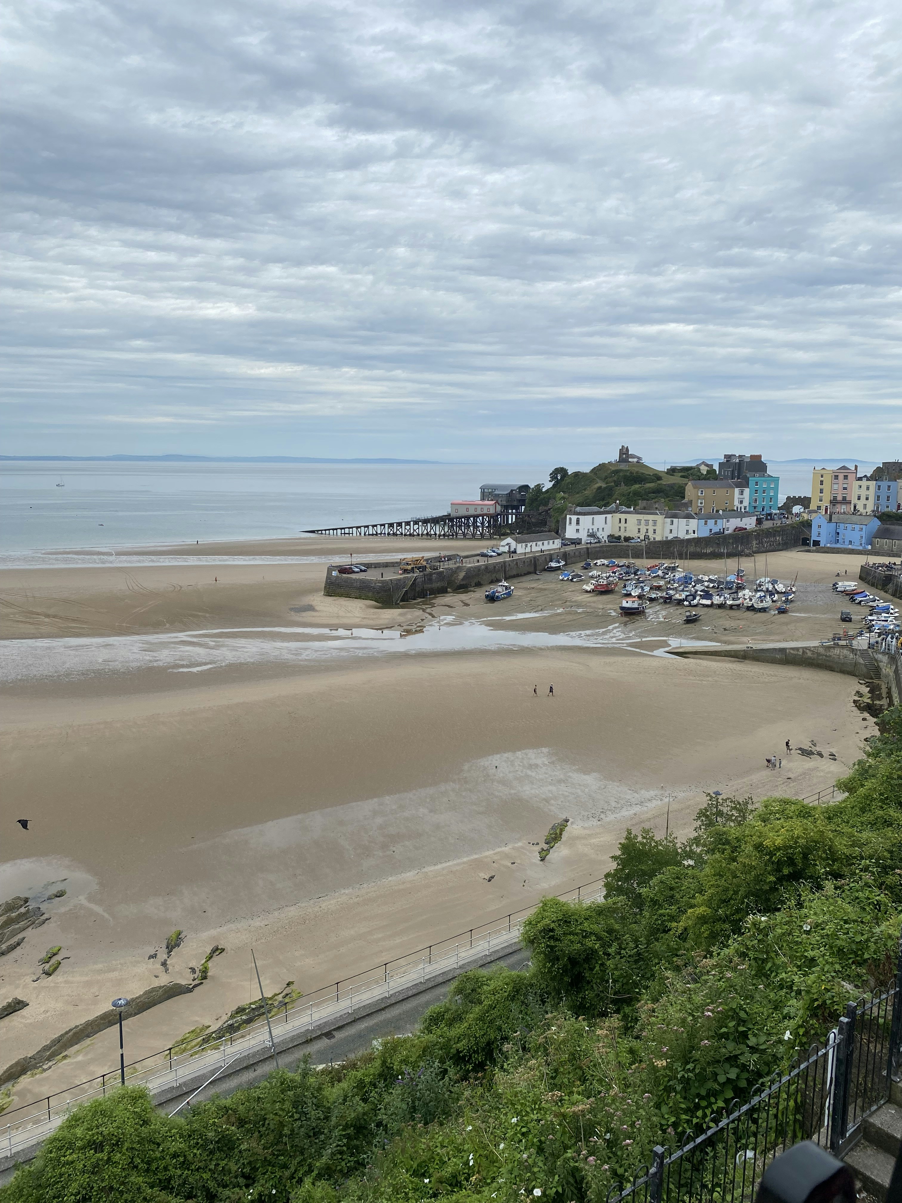 A beach with a pier and buildings photo – Free Tenby Image on Unsplash