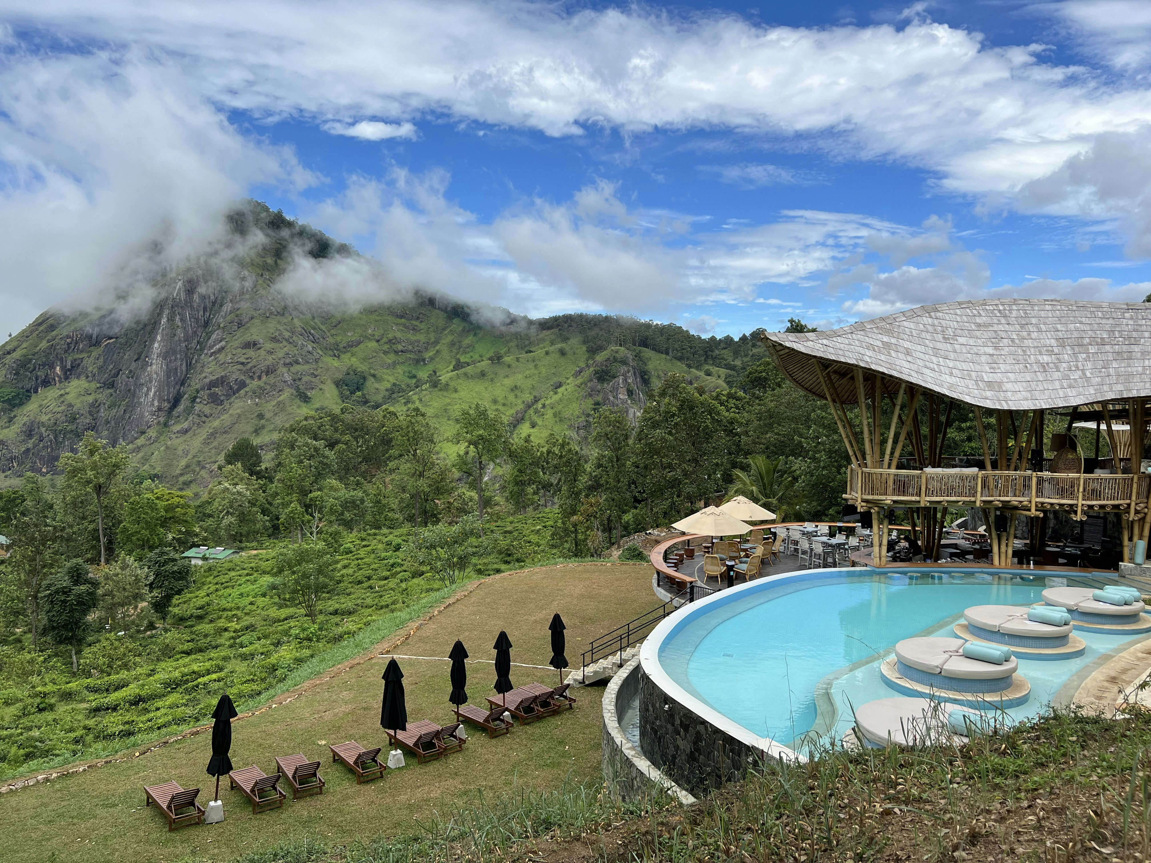 A swimming pool in a valley with trees and mountains in the background ...