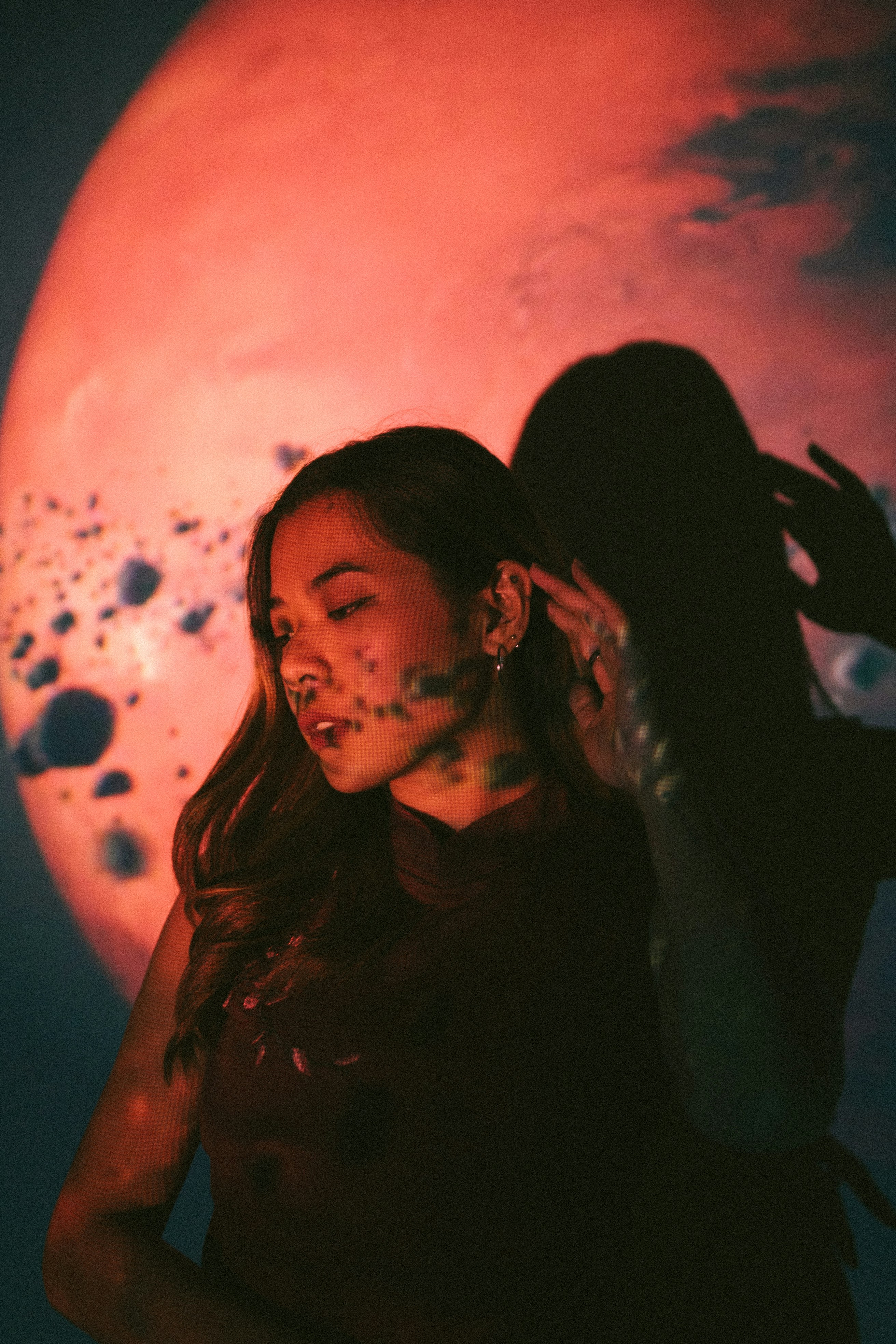 Shadowed Portrait Beneath a Crimson Orb