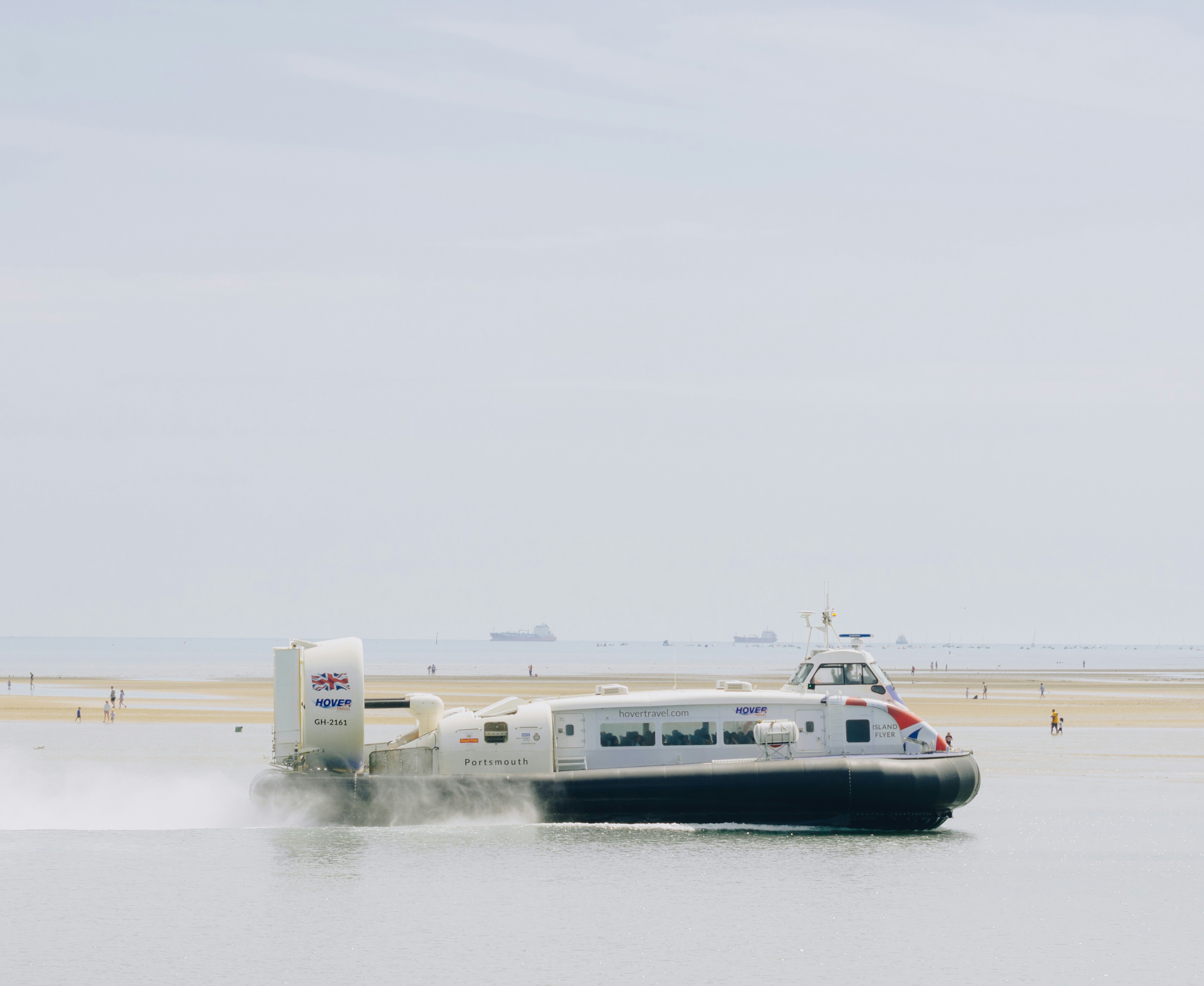 Tide-Line Transit: A White Hovercraft Skims the Still Shore