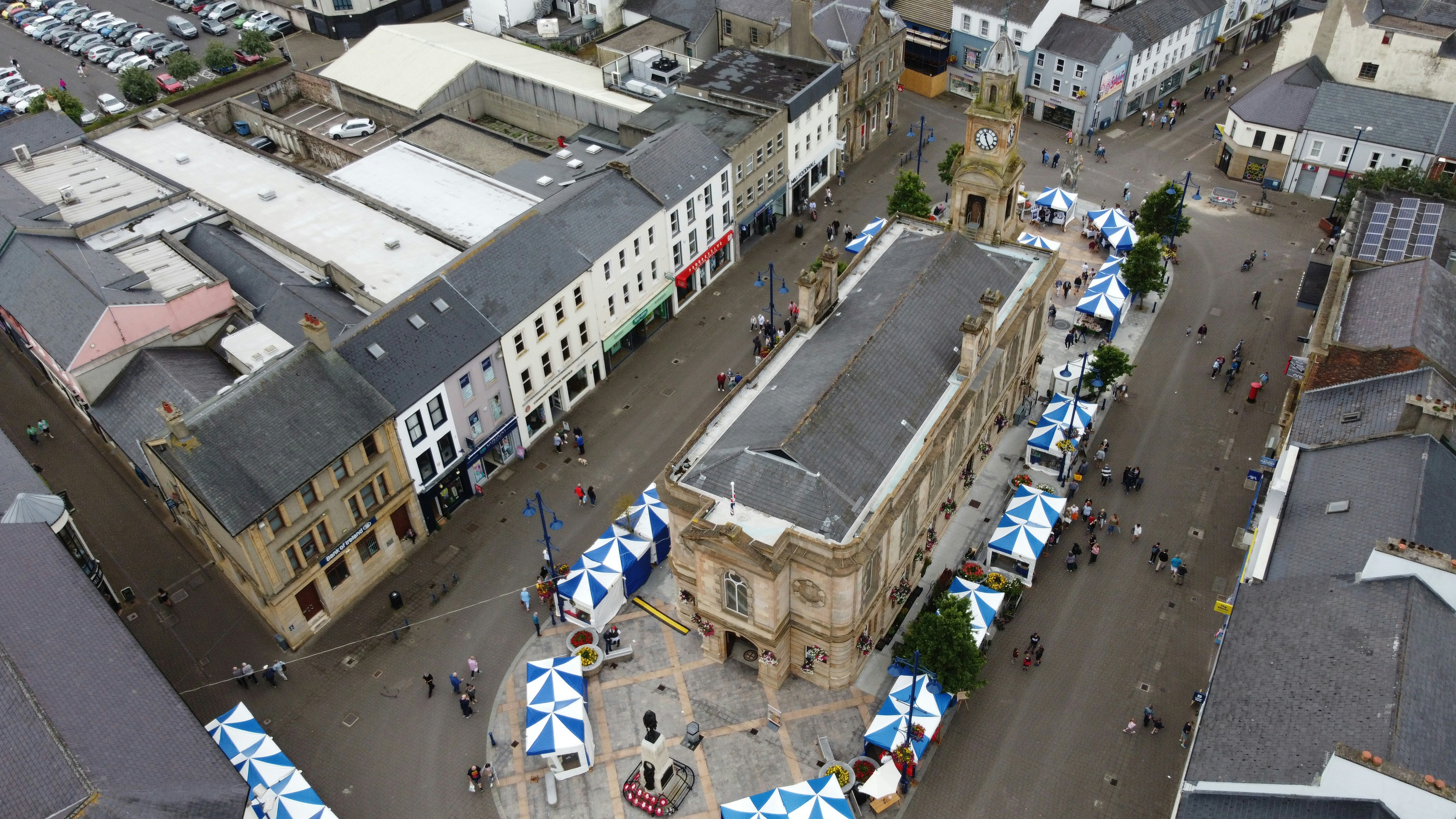 A group of people walking around a large building photo – Free Causeway ...