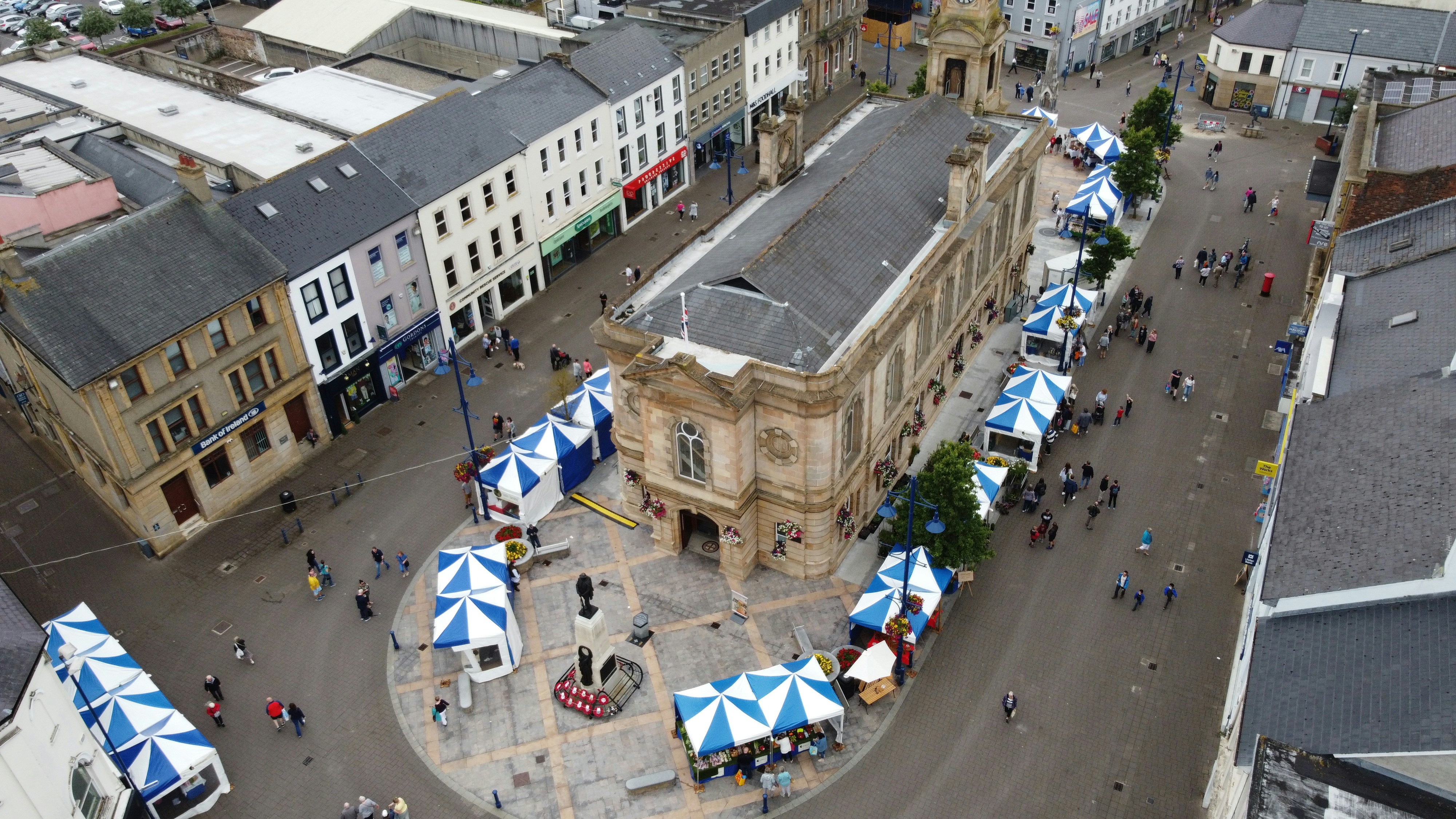 A group of people walking around a town square photo – Free Causeway ...
